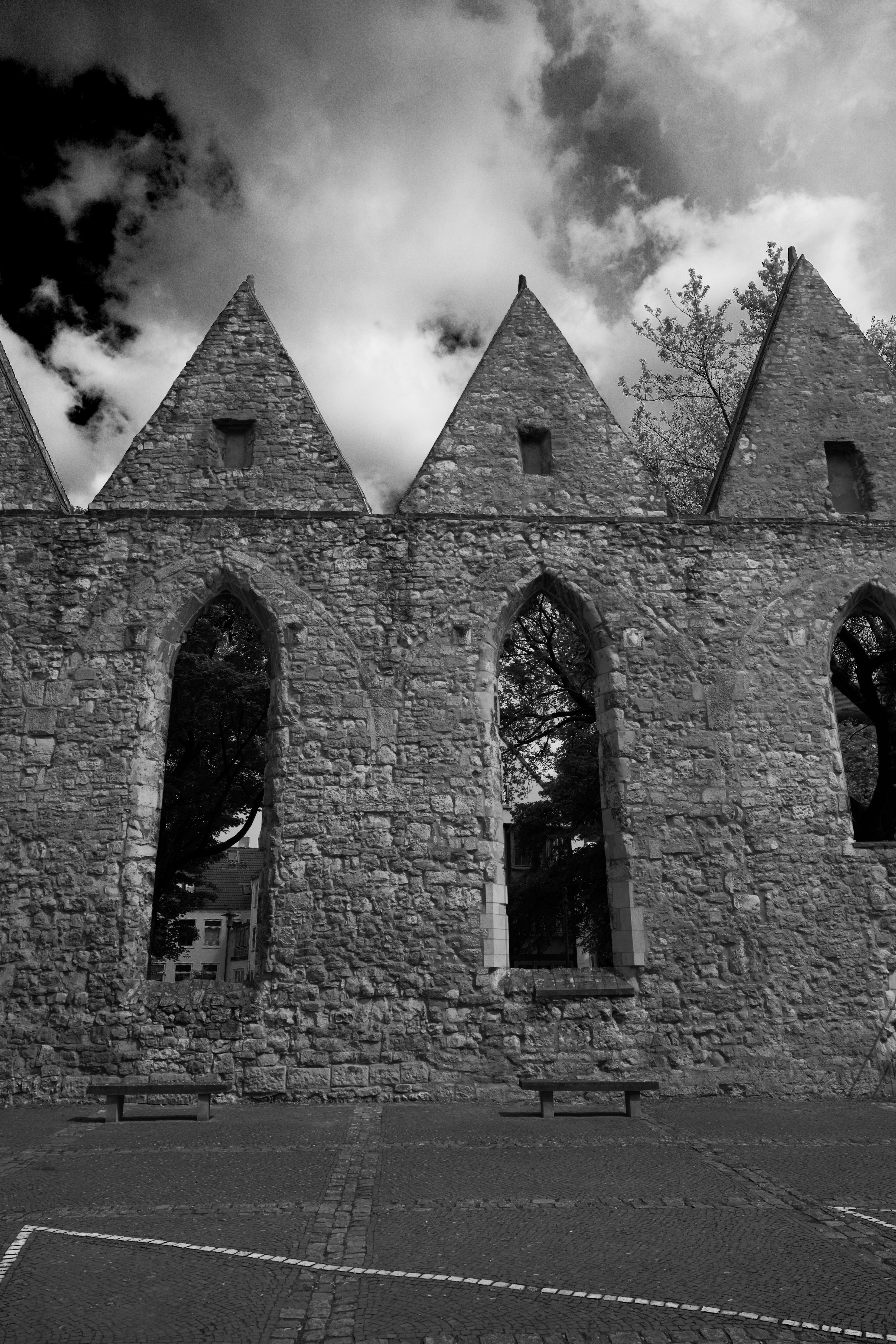 Ruined Gothic Wall with Arched Windows Under a Dramatic Sky