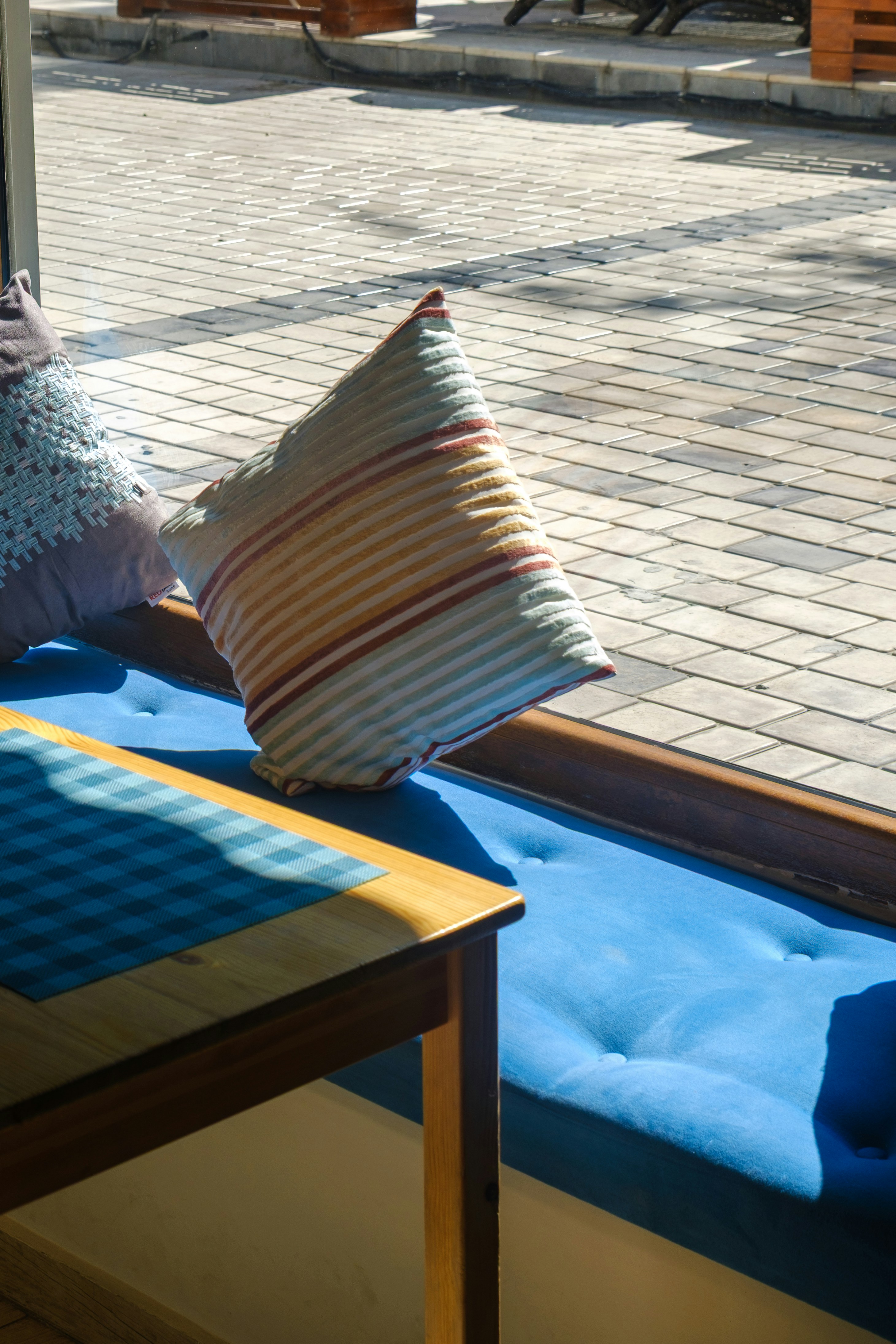 Sunlit Lounge Cushions on a Blue Cushioned Bench