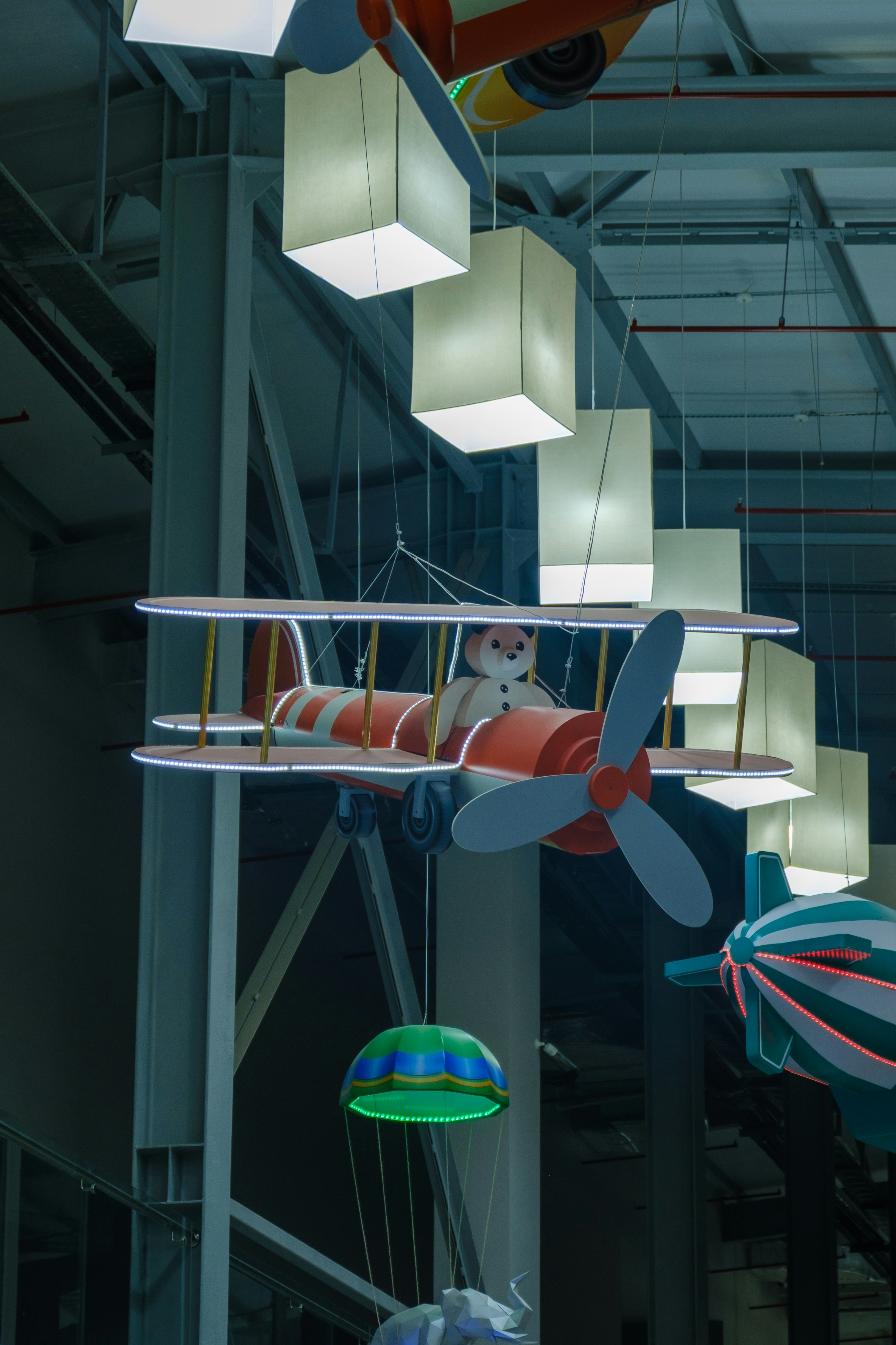 Suspended Airplane Toy Under Soft Neon Glow