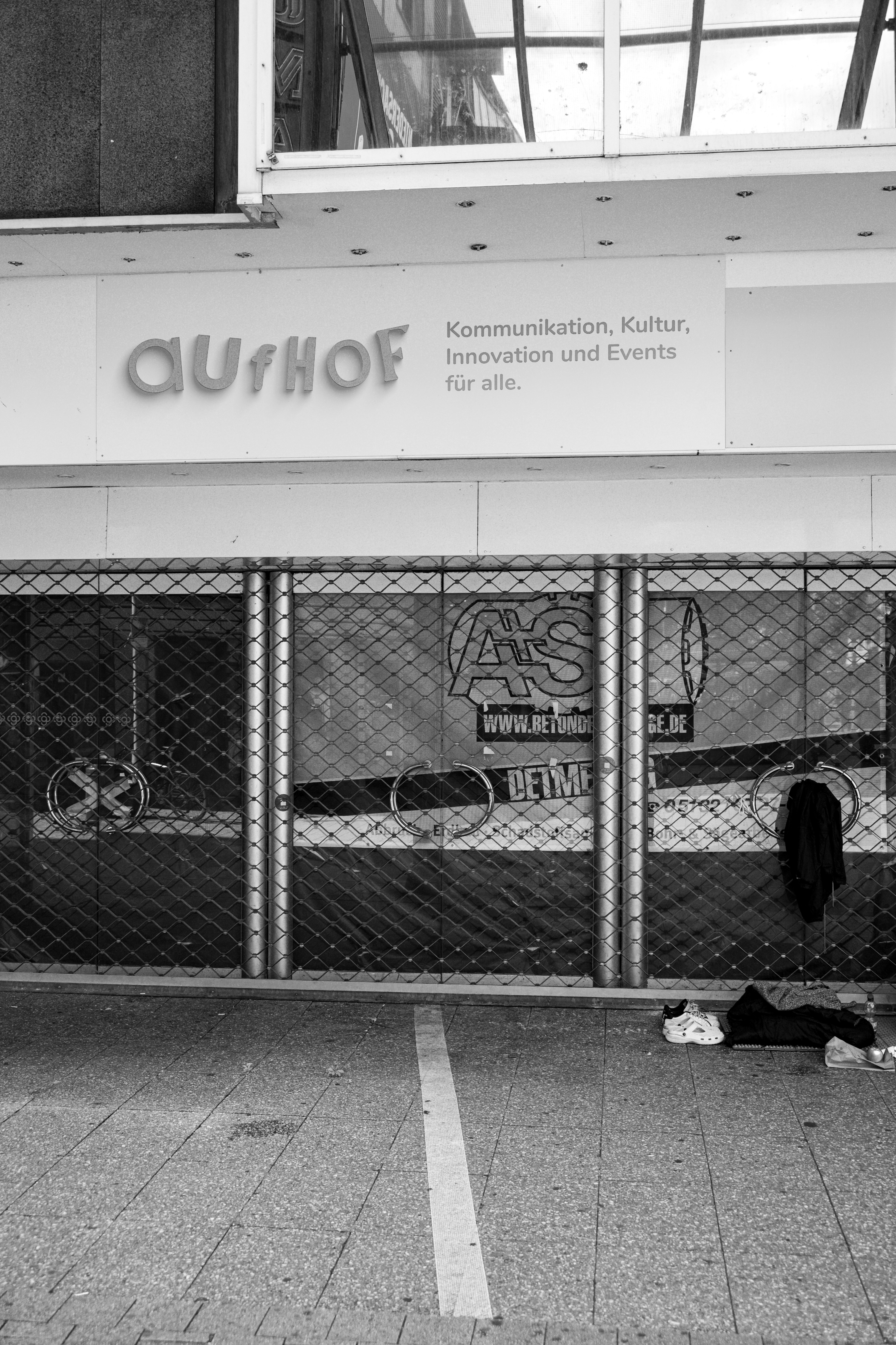 Closed-up storefront guardians: a monochrome street scene