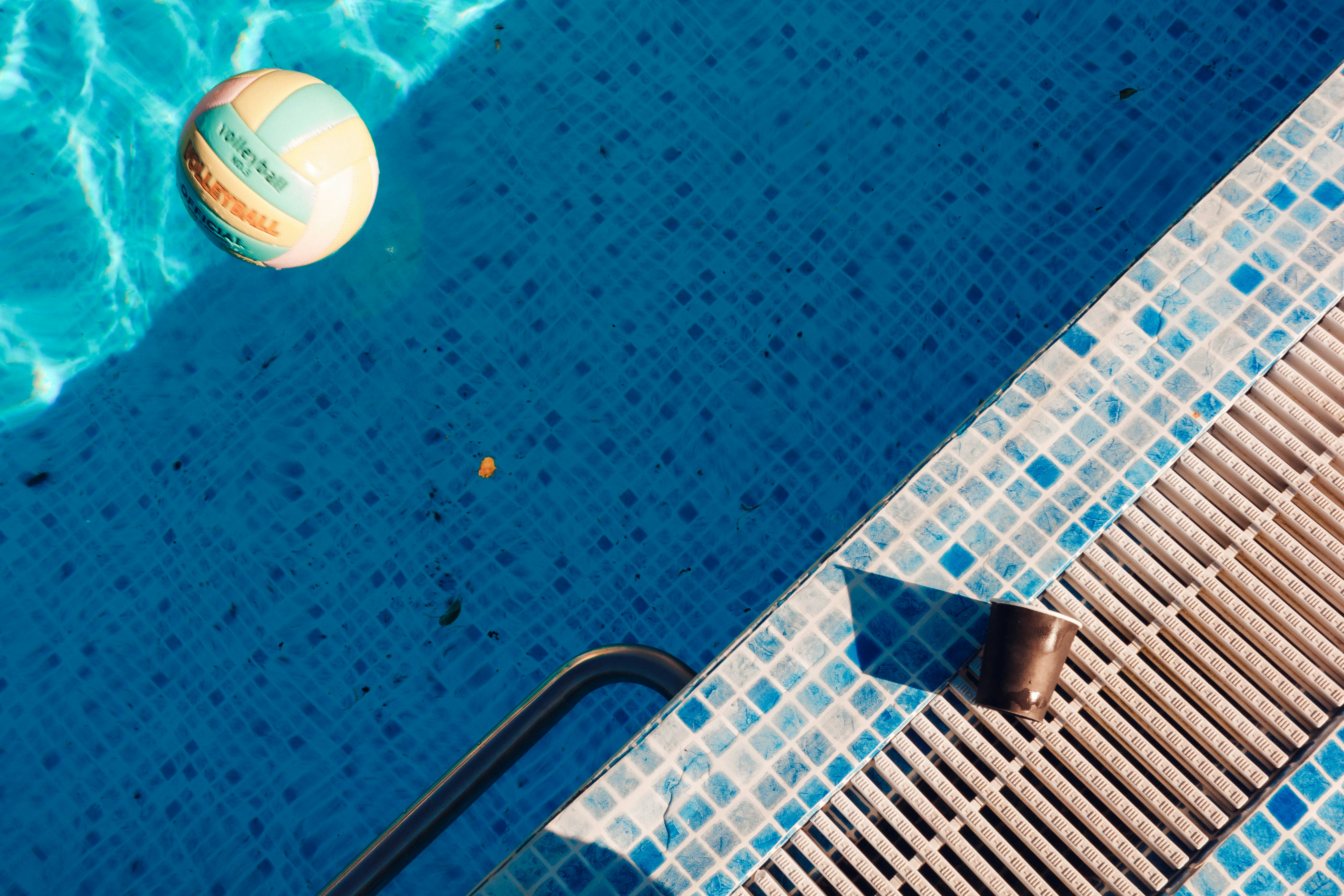 Blue-Tiled Poolside Moment with a Floating Ball