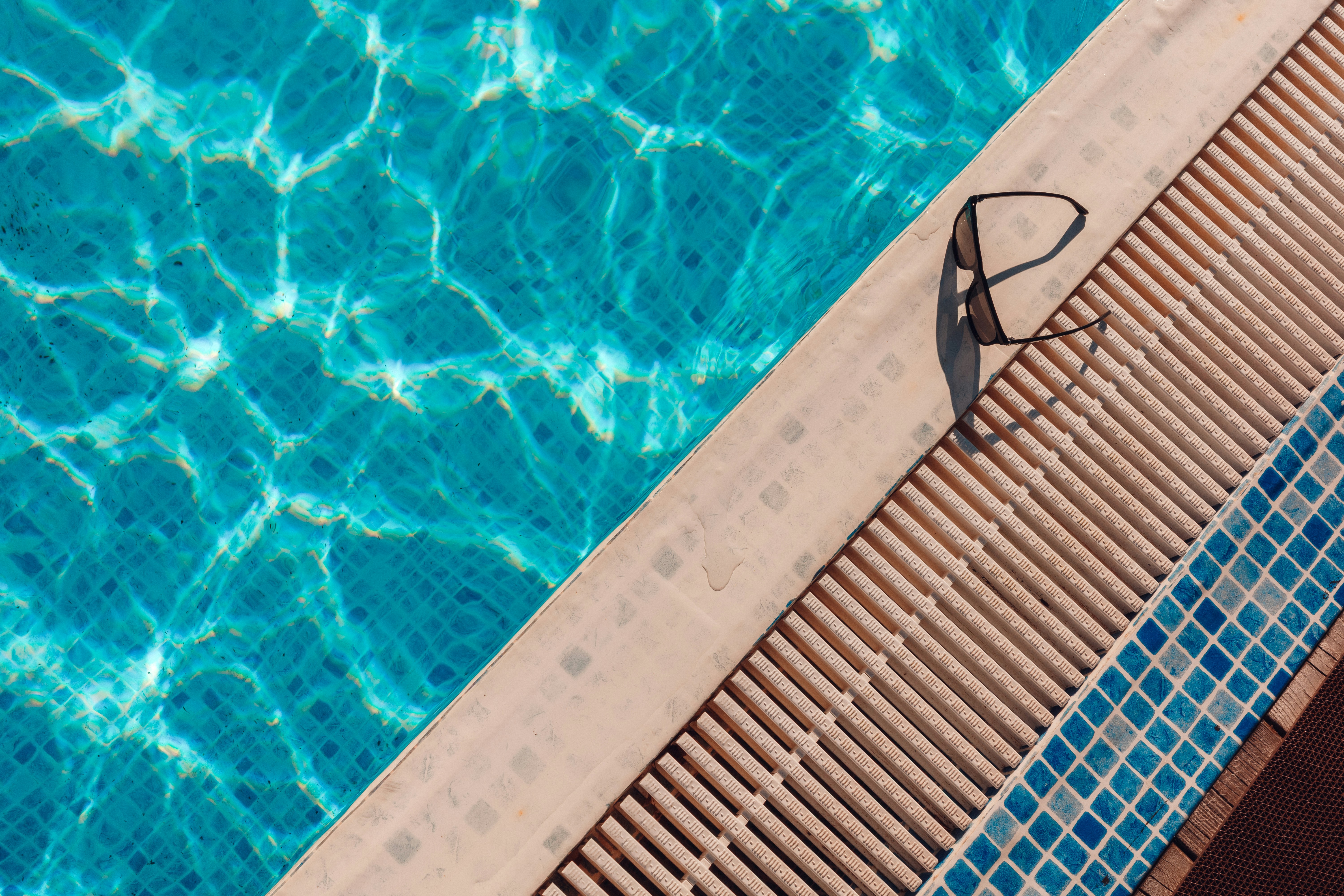 Edge of Chill: Sunlit Blue Pool and Concrete Grates