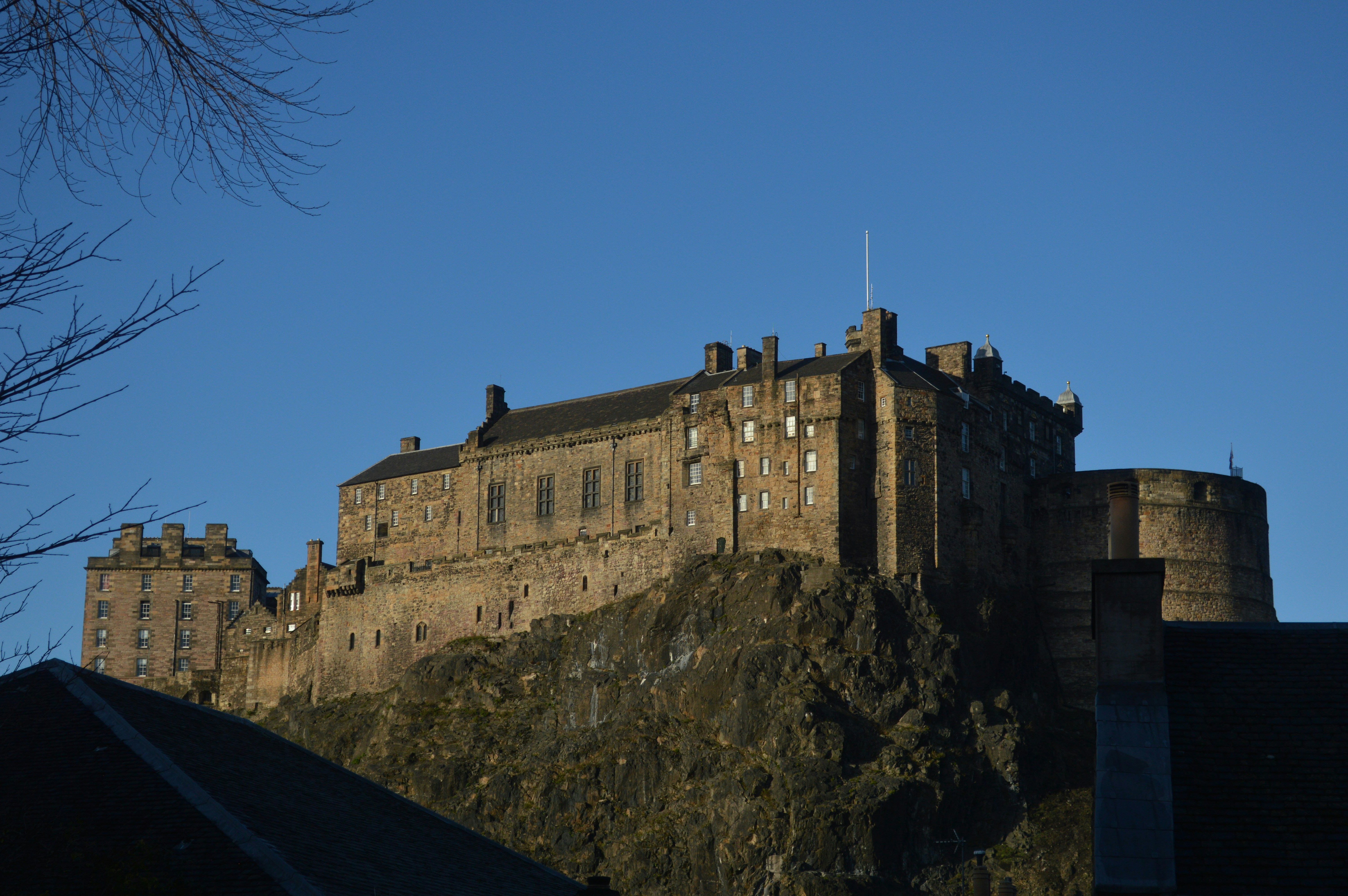 Castle on the Hill: A Stoic Granite Keep Under A Clear Blue Sky