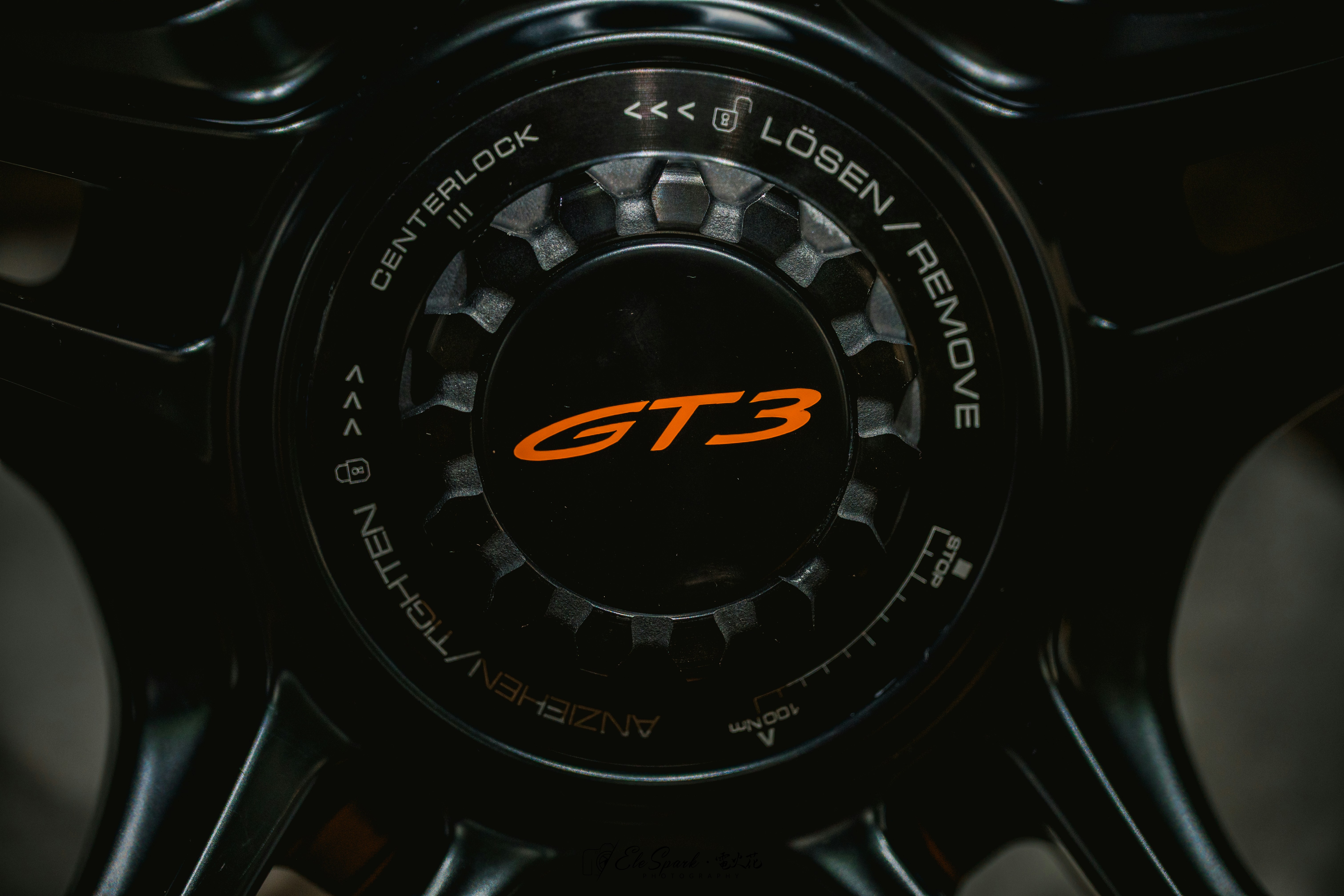 Orange GT3 Emblem Framed by Car Rim