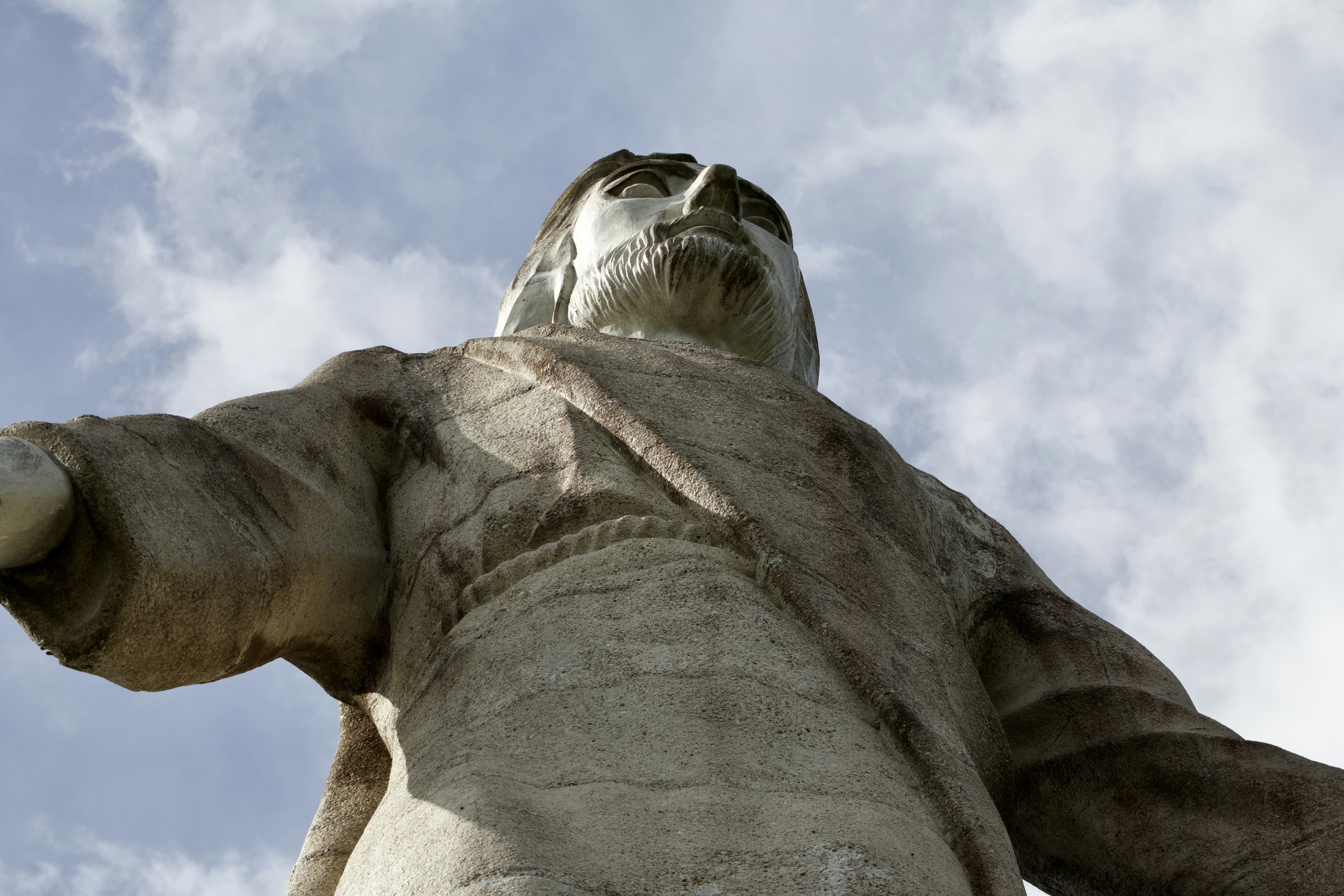 Upward Gaze: A Monumental Statue Reaching Toward the Sky