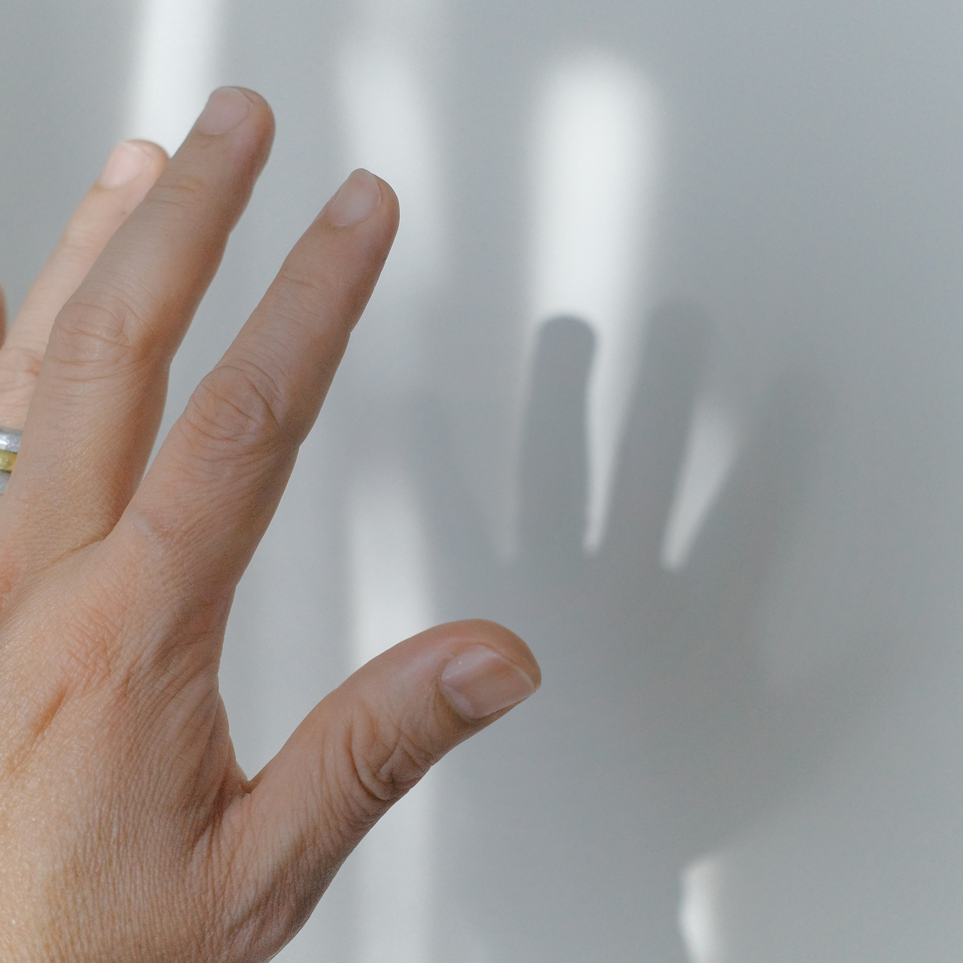 Shadowed Handprint on a Misty Glass