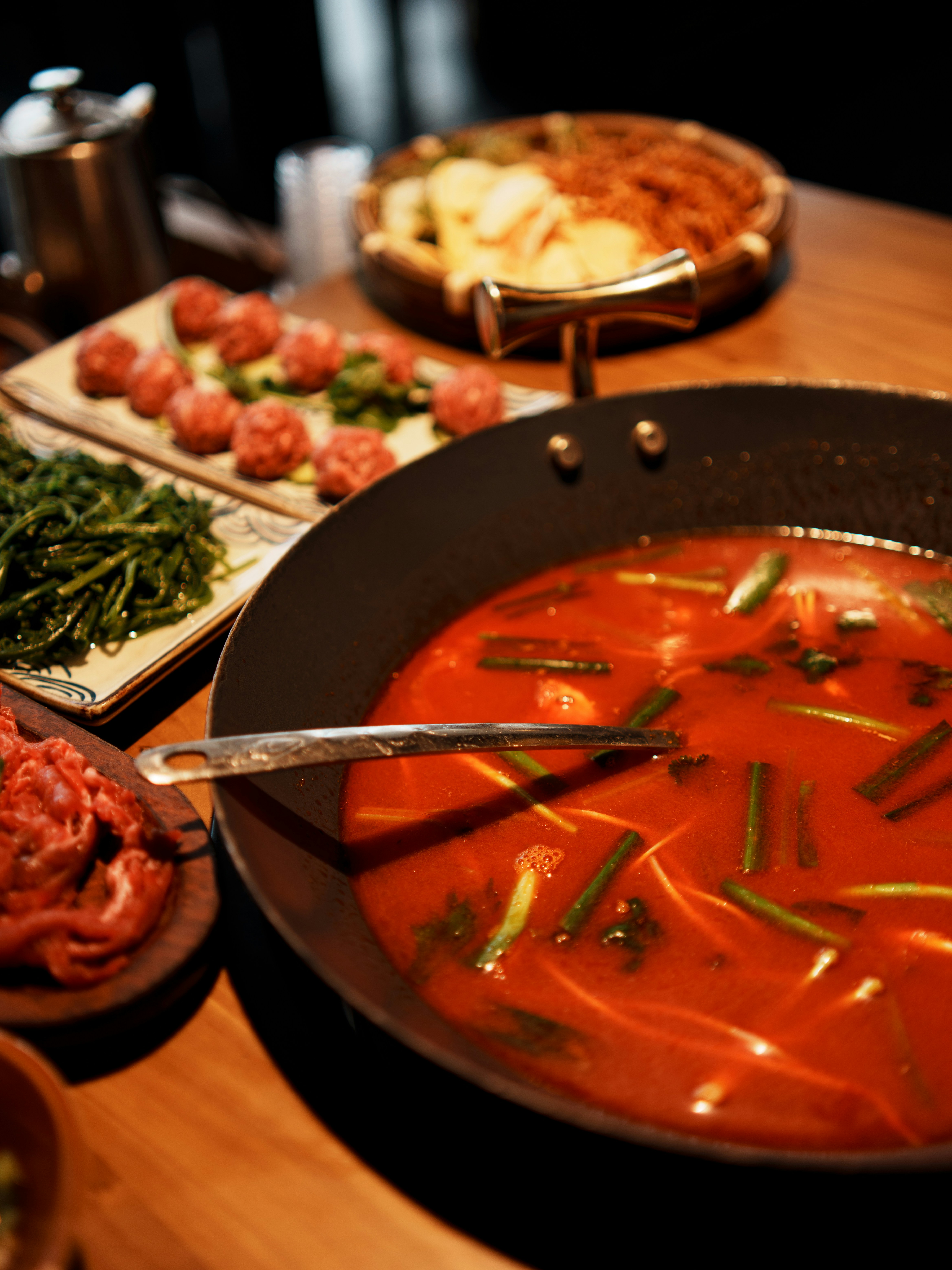 Fire-Kissed Pot: A Smoke-Hued Pan of Spiced Soup at a Lively Table