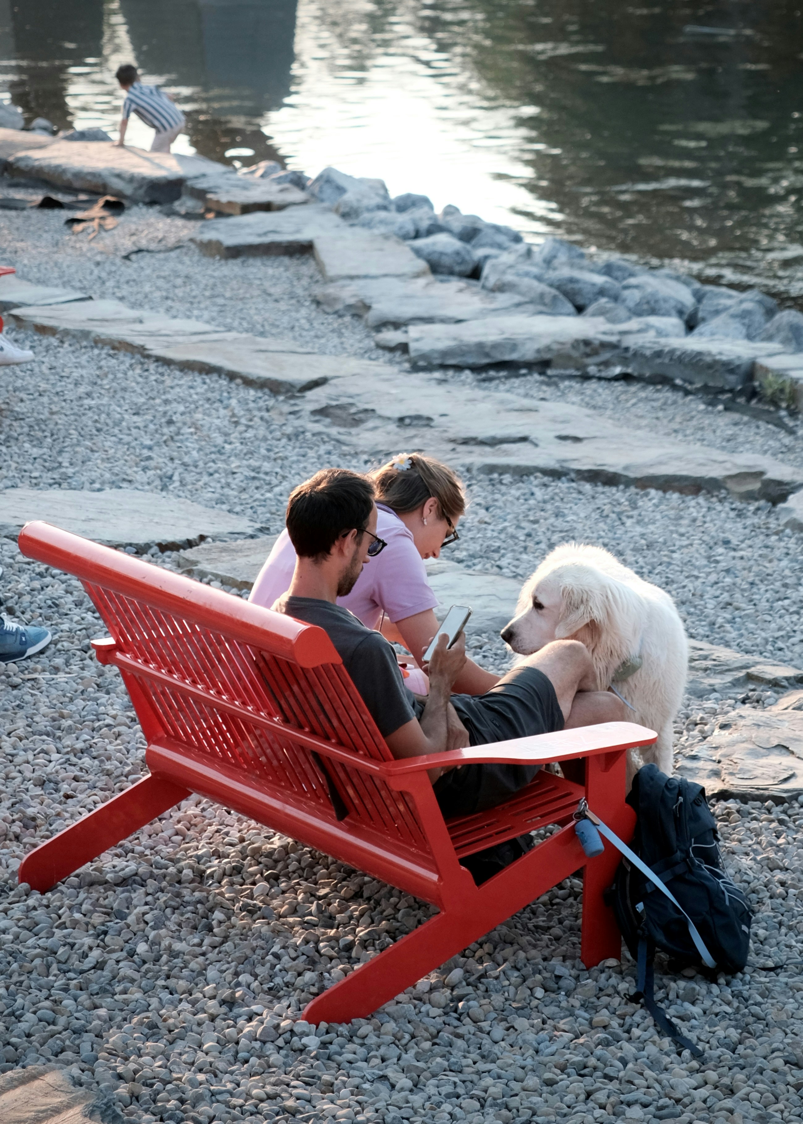 Red Bench, Quiet Moment: Friends and Dog by the Water