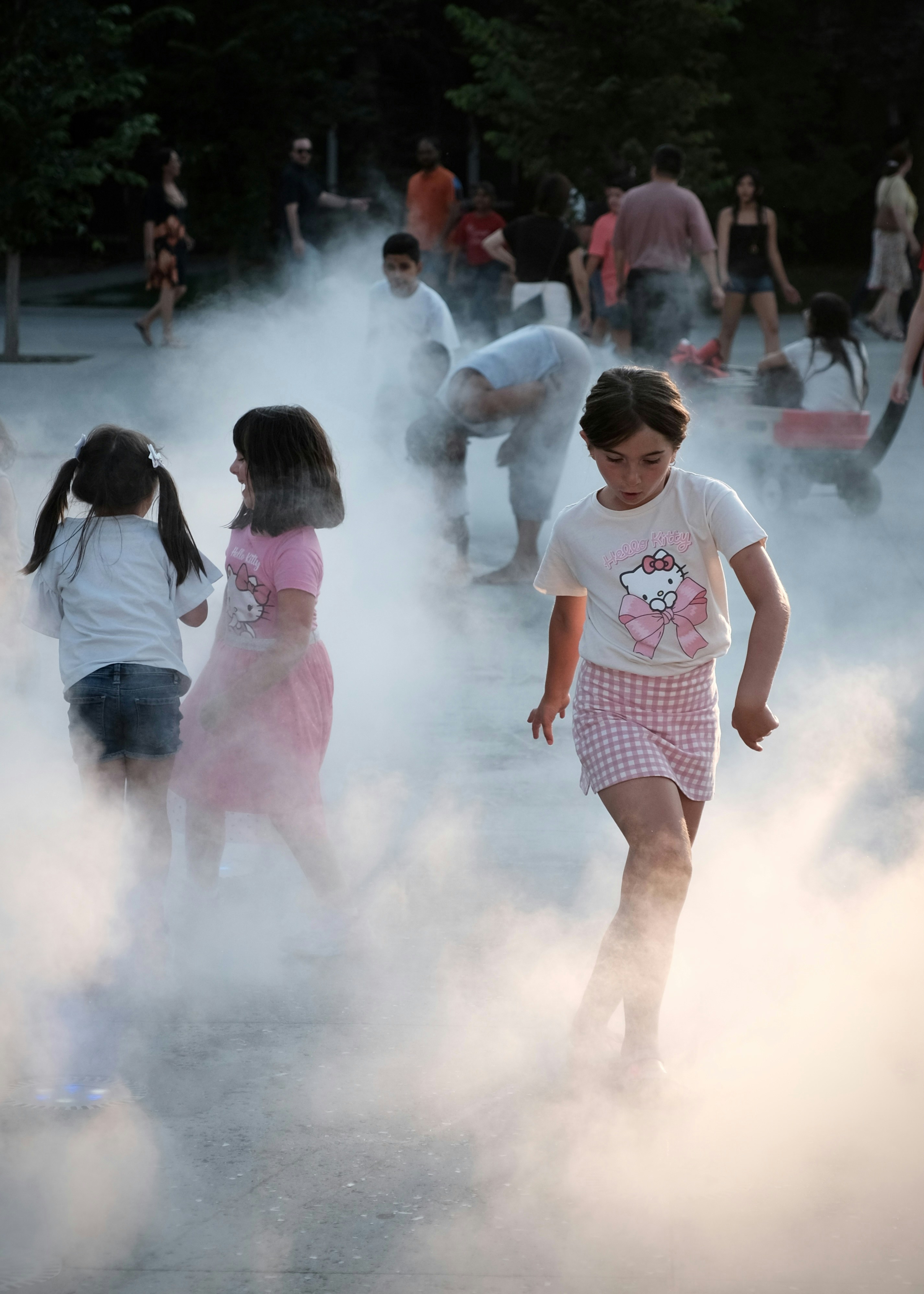 Girl in White Hello Kitty Tee Steps Through Fog as Park Scene Bubbles with Playful Energy