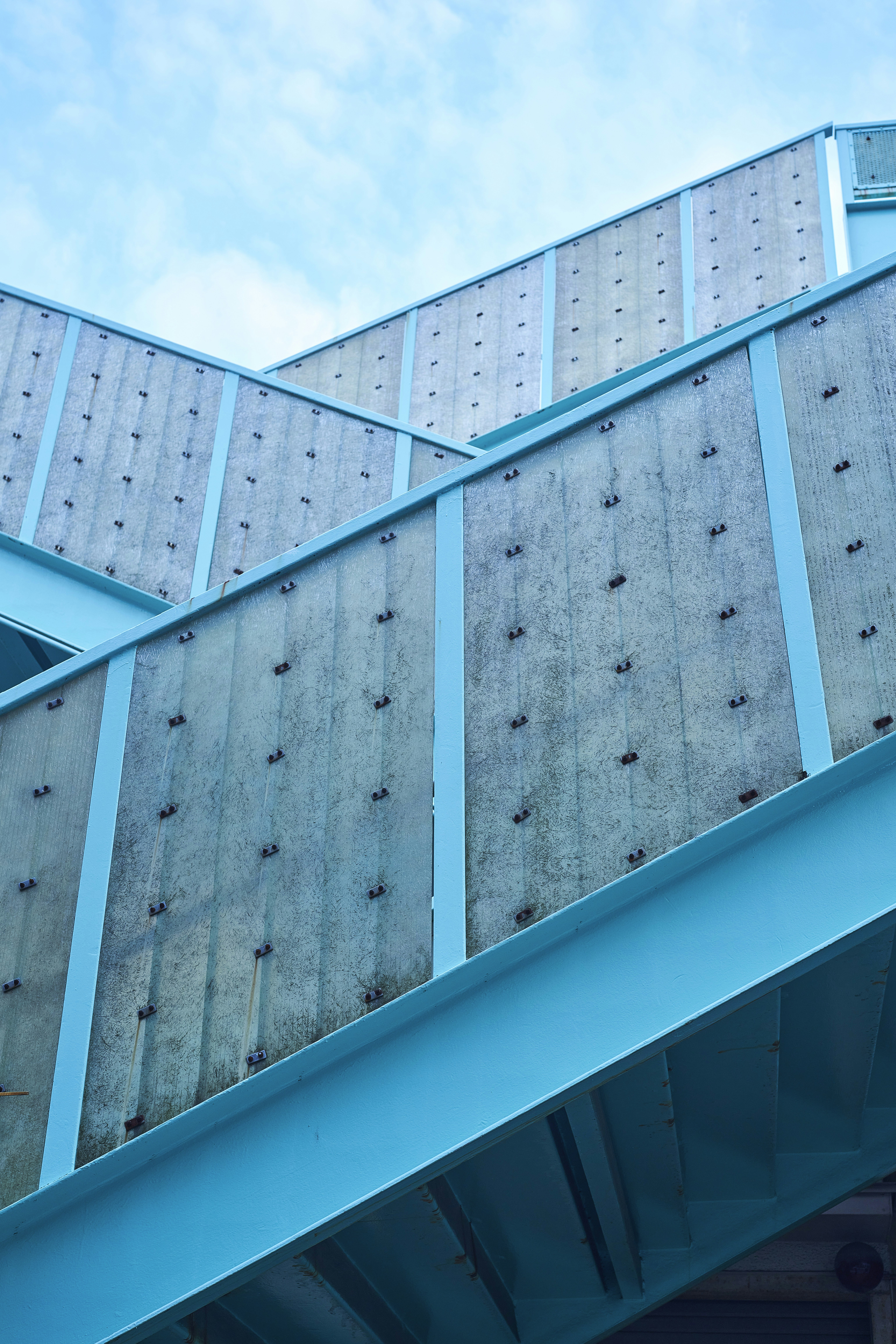 Azure Facades: Angular Lines on a Cyan Stairwell