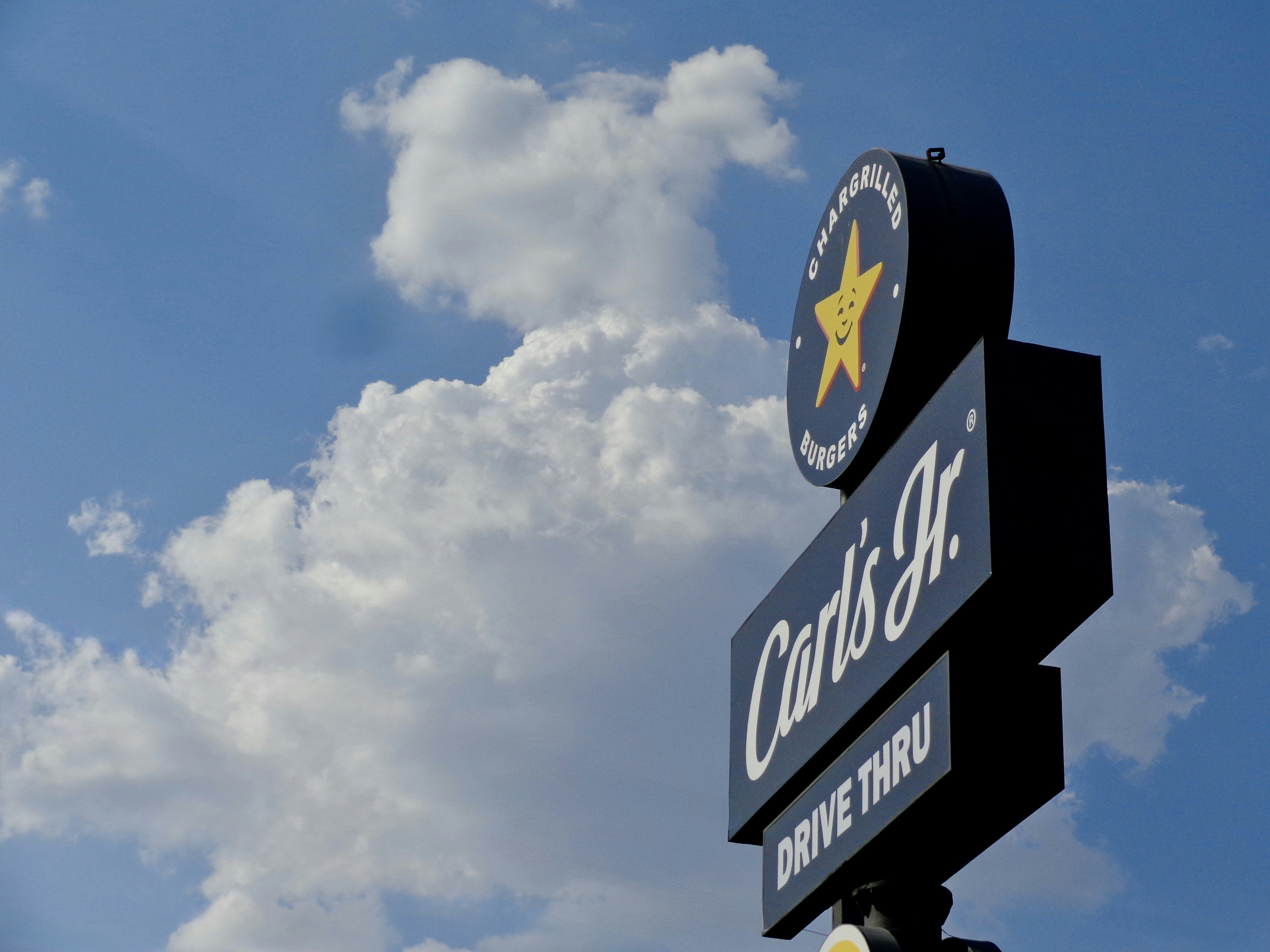 Blue Sky, Neon Sign: A Drive-Thru Card Shop under Open Clouds