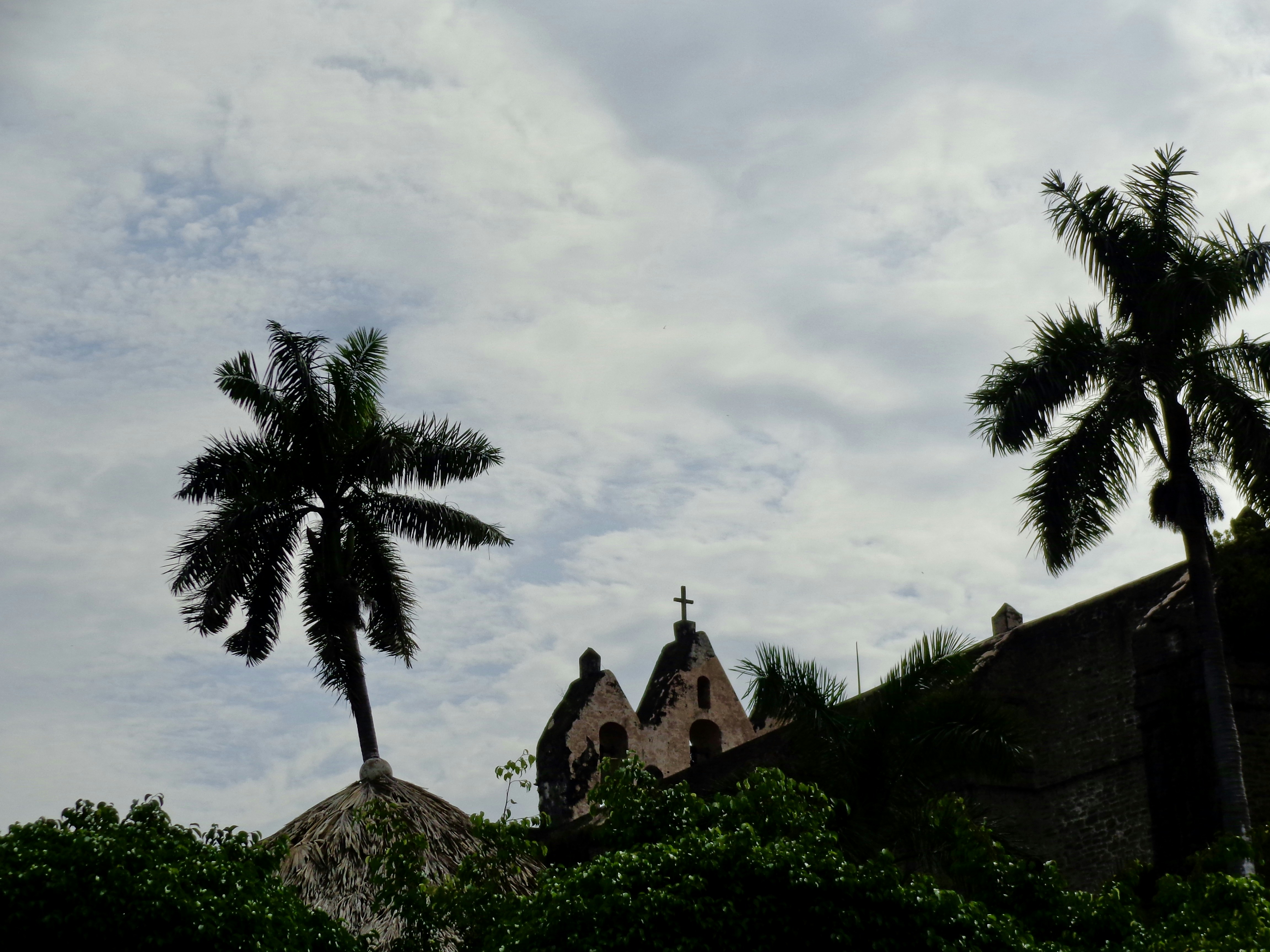 Palm silhouettes over a colonial chapel