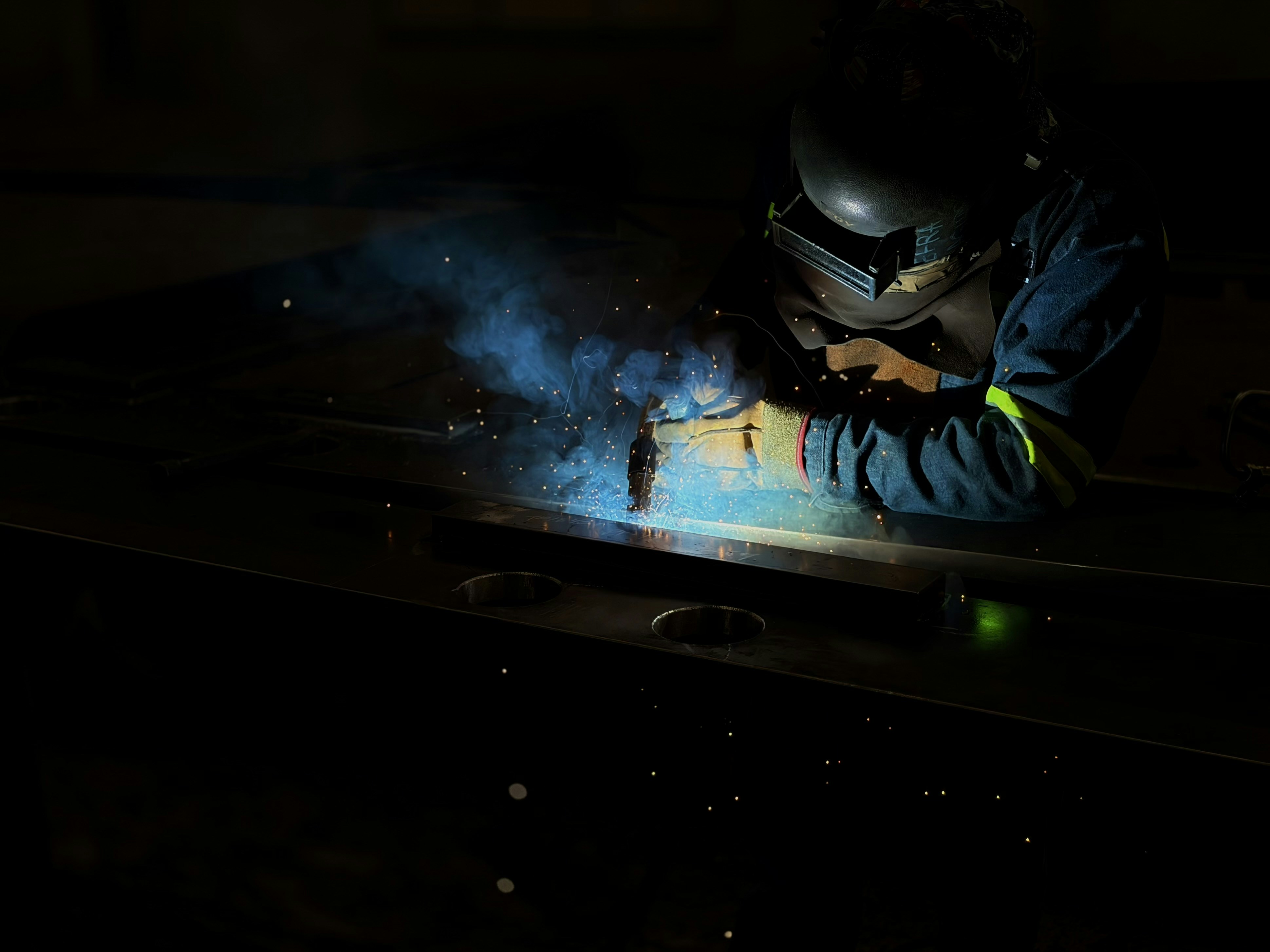 Blue Sparks on Steel: Hands in Focus