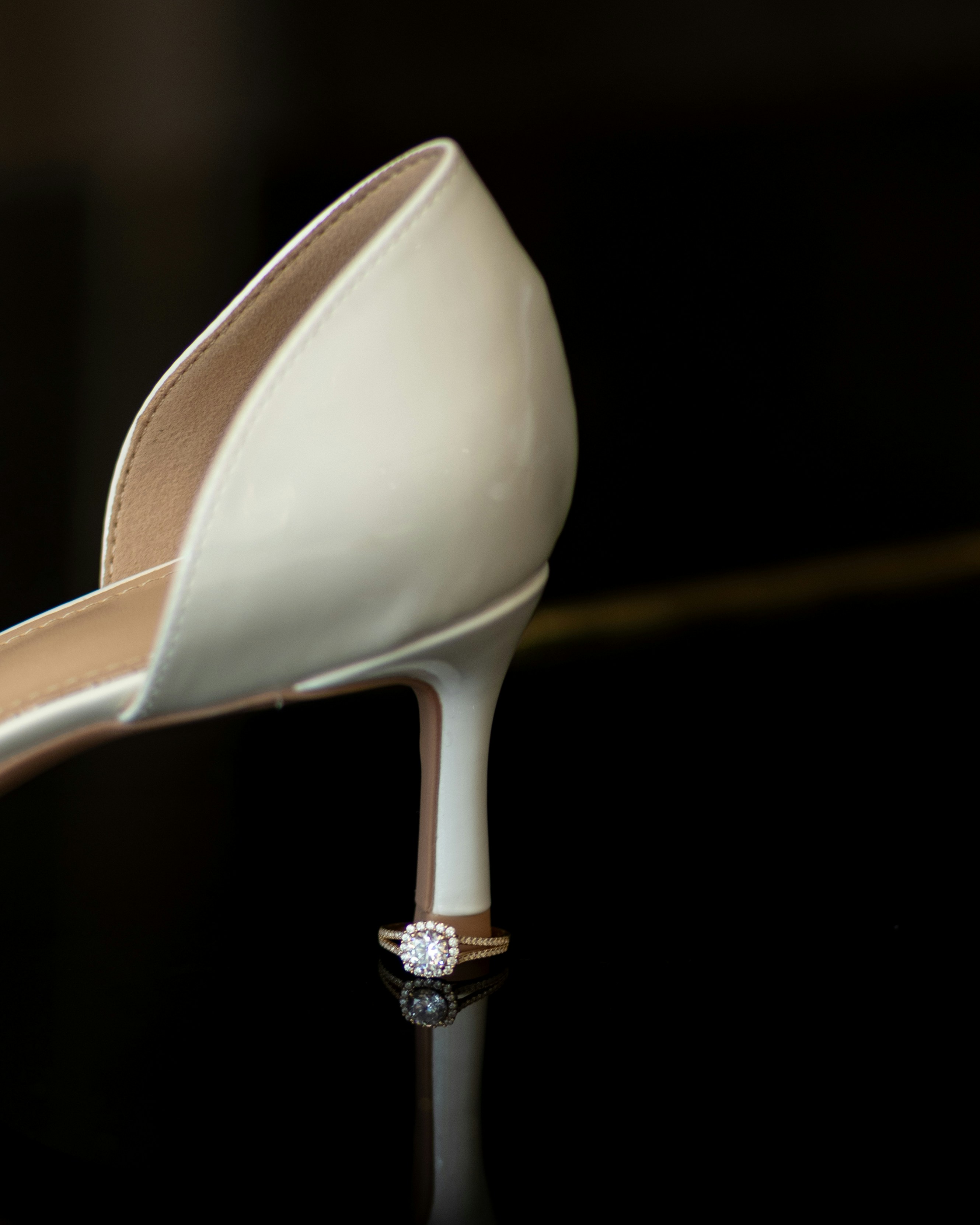 Elegantly Resting on Glass: A White Heel and Ring