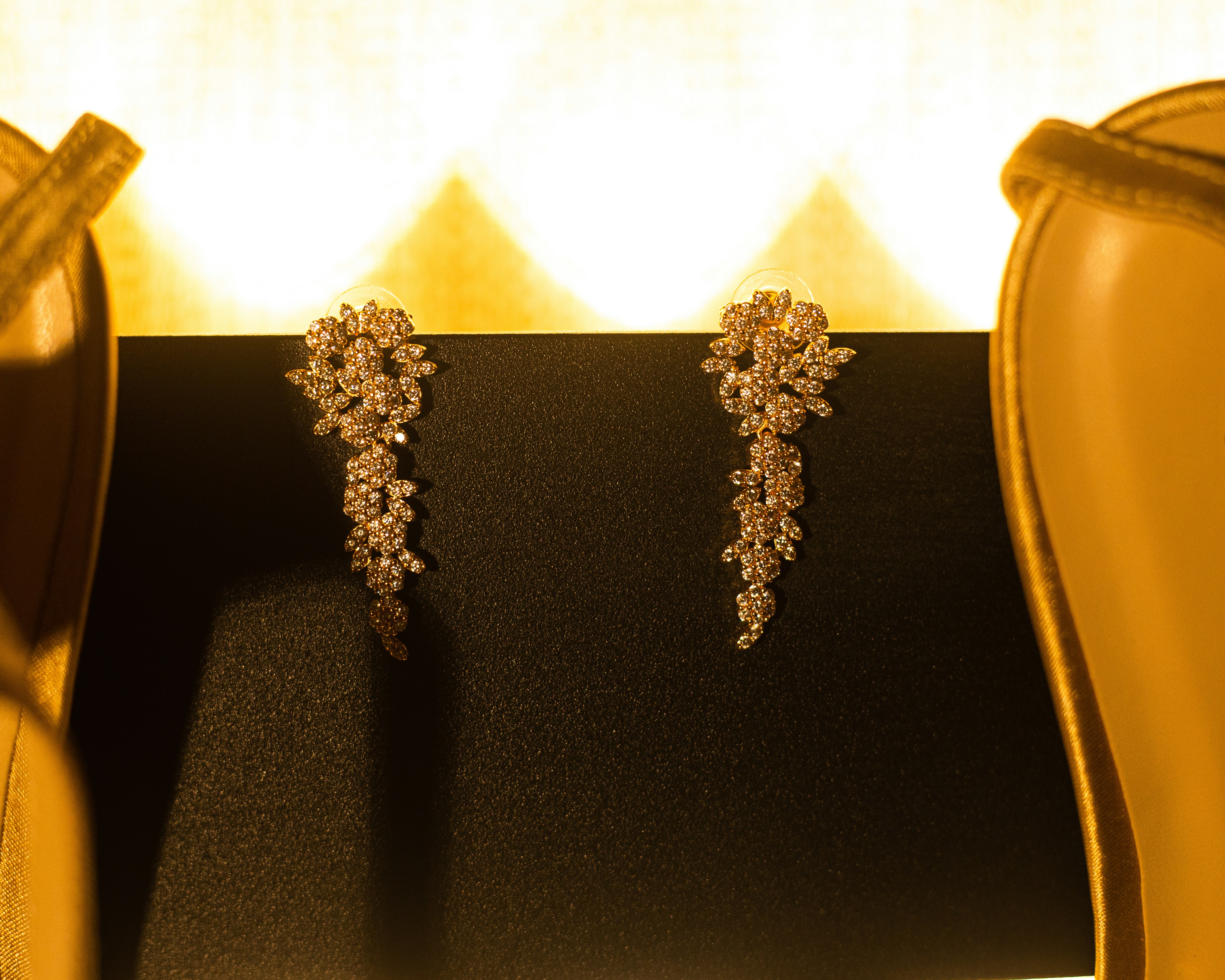 Diamonds in the Spotlight: Dangling Elegance Between Golden Seats