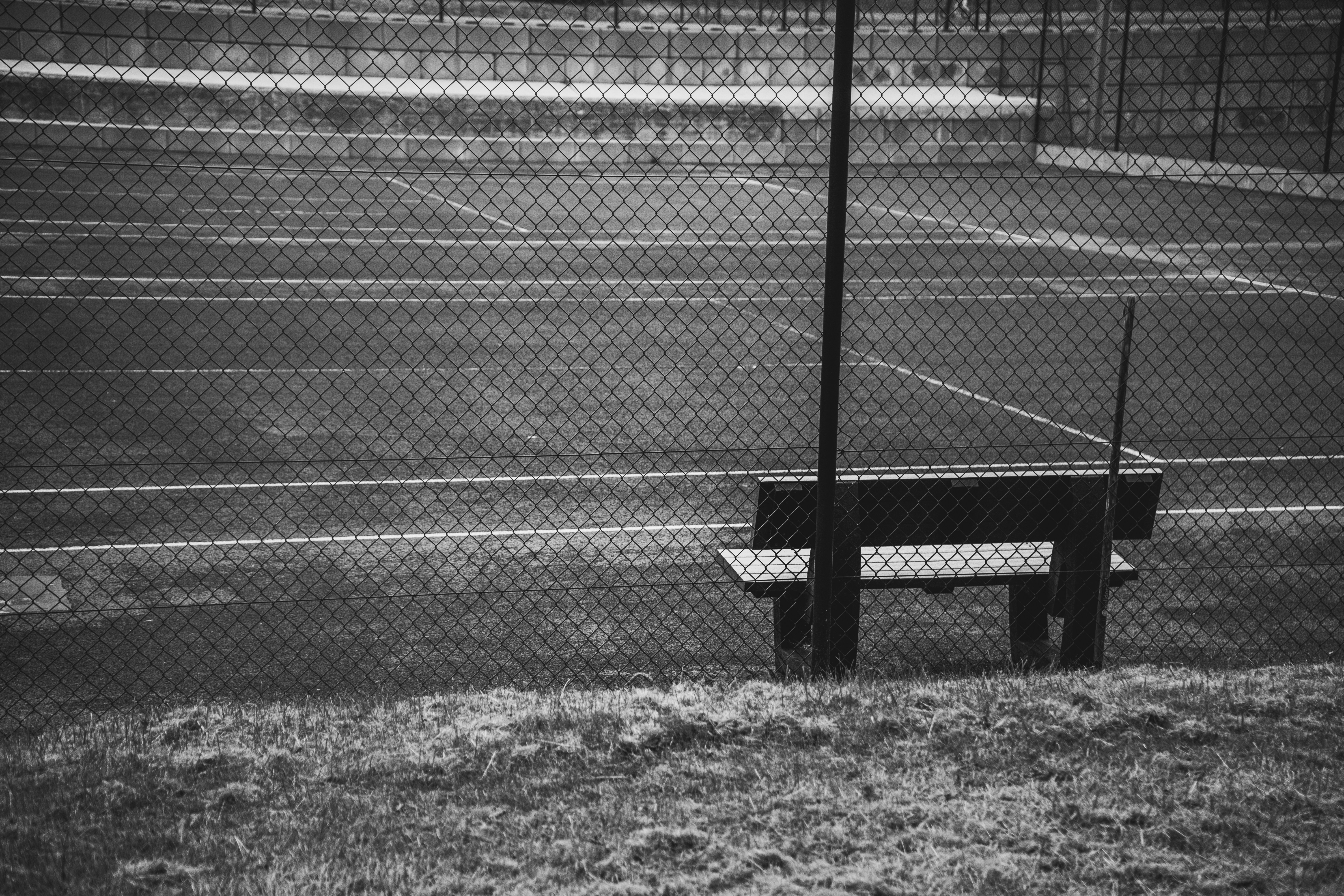 Empty Park Bench Beyond the Chain-Link Quiet