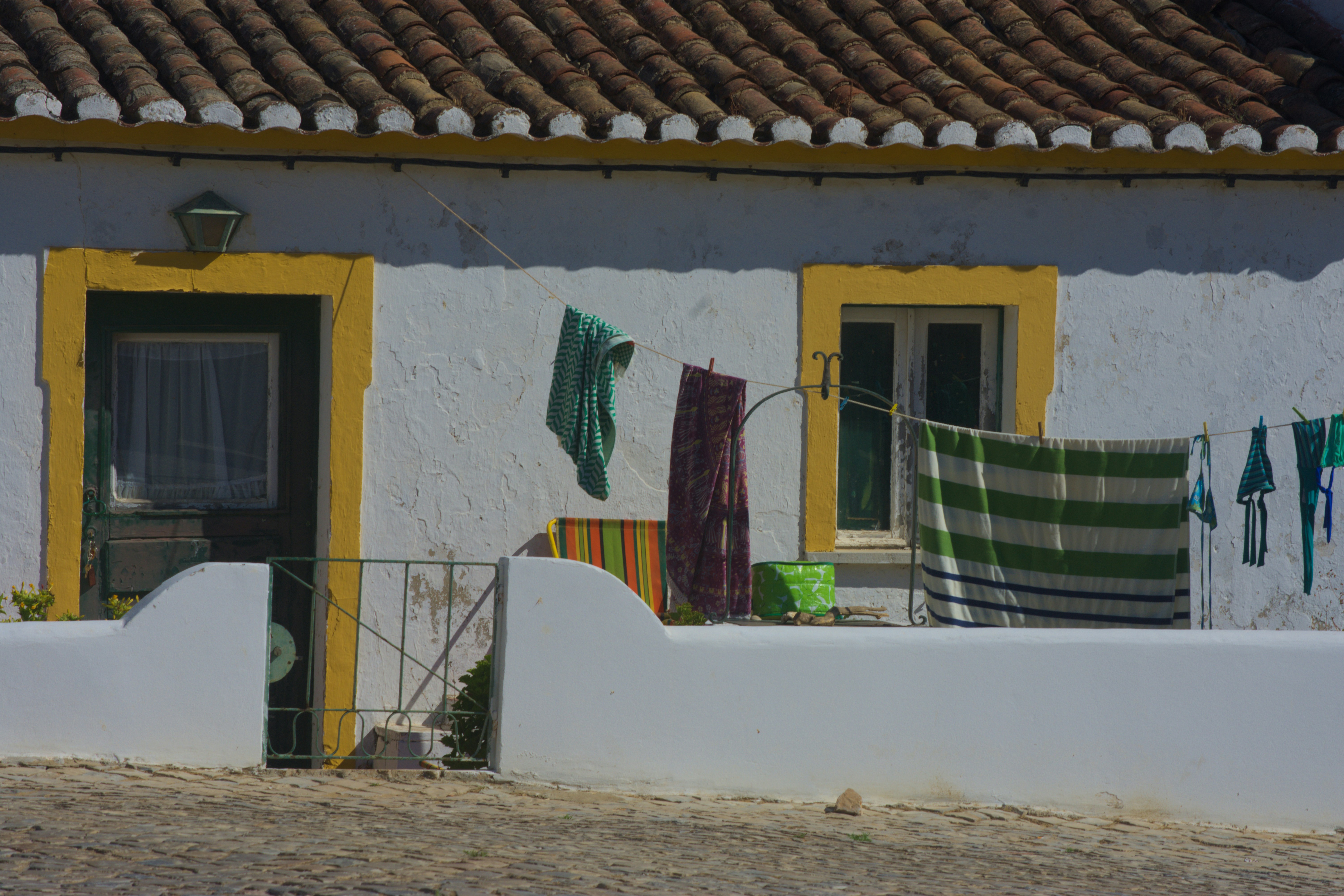Sunlit Cottage with Laundry Lines on a Whitewashed Façade