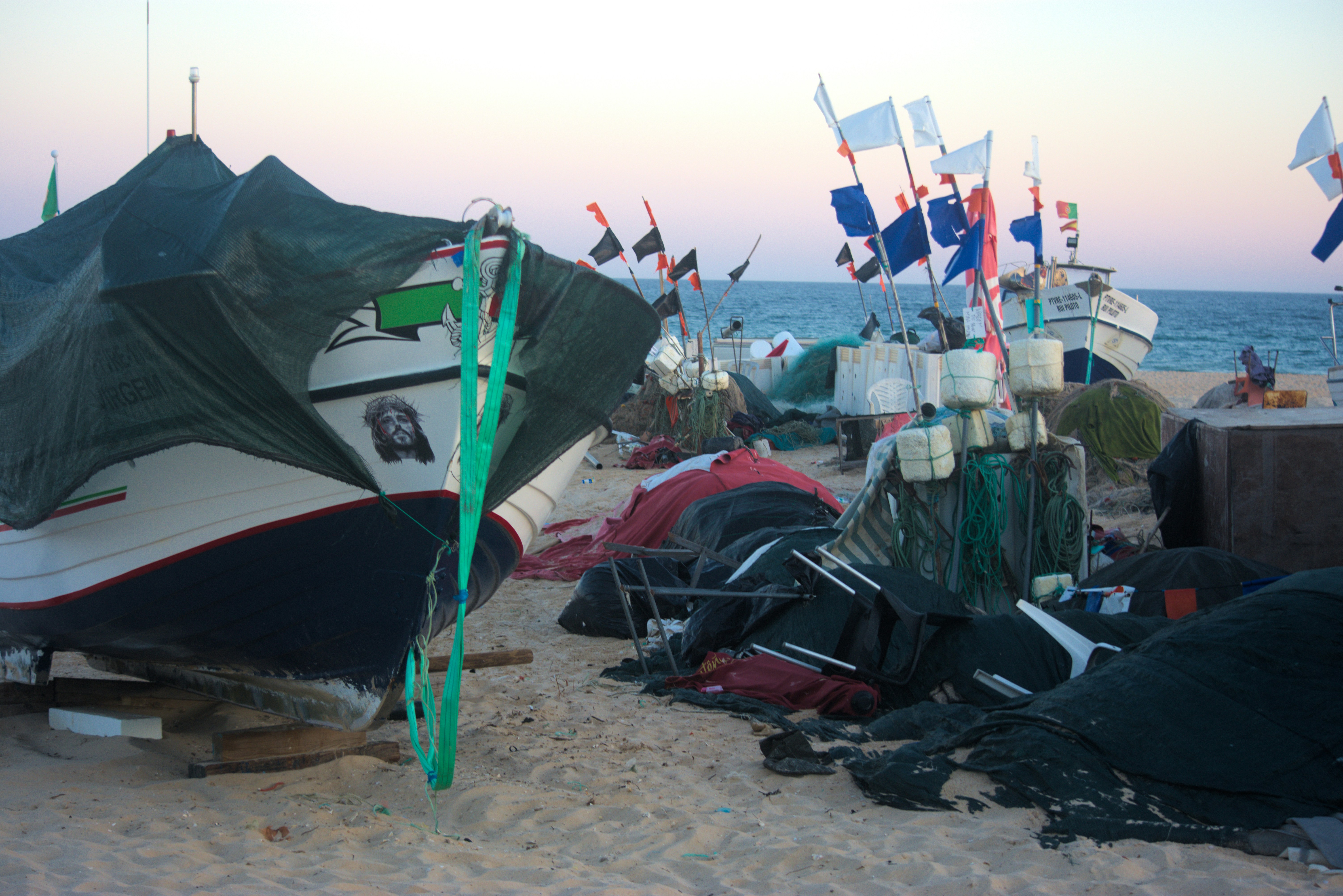 Sunlit Boats and Tense Nets on a Wind-Swept Beach
