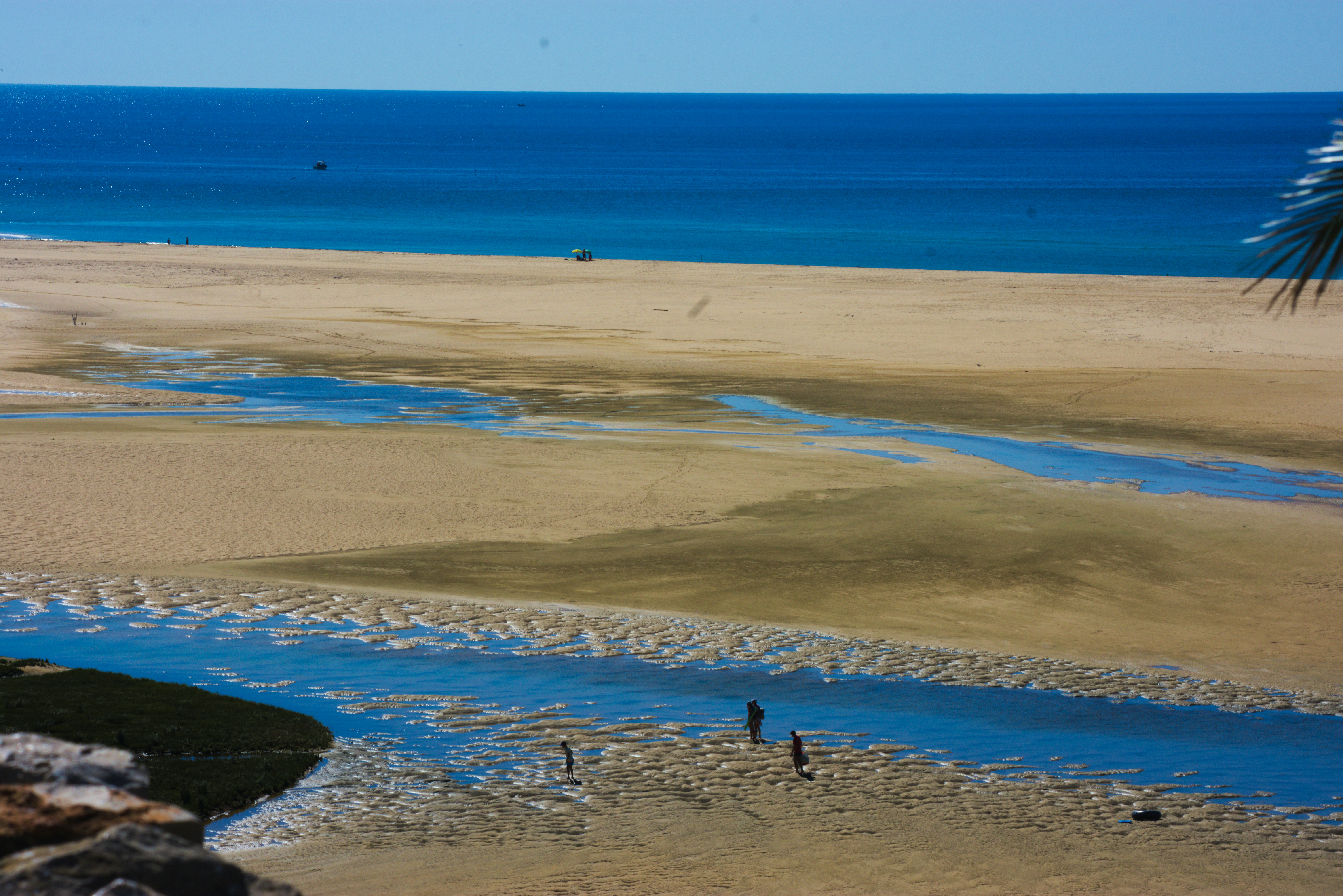 Deserted shoreline channels weave toward a distant blue horizon