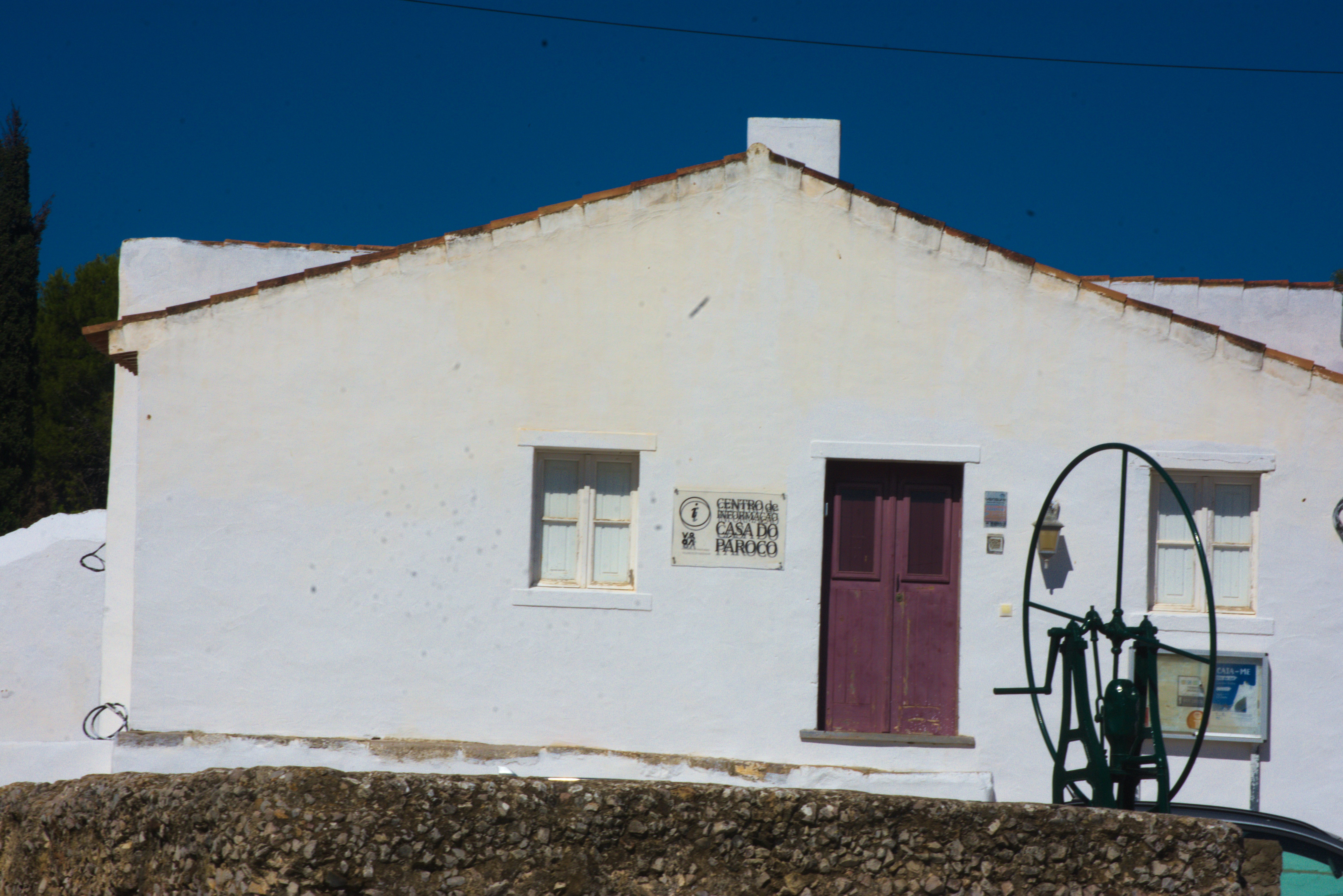 White-walled building with a purple door under a sapphire sky