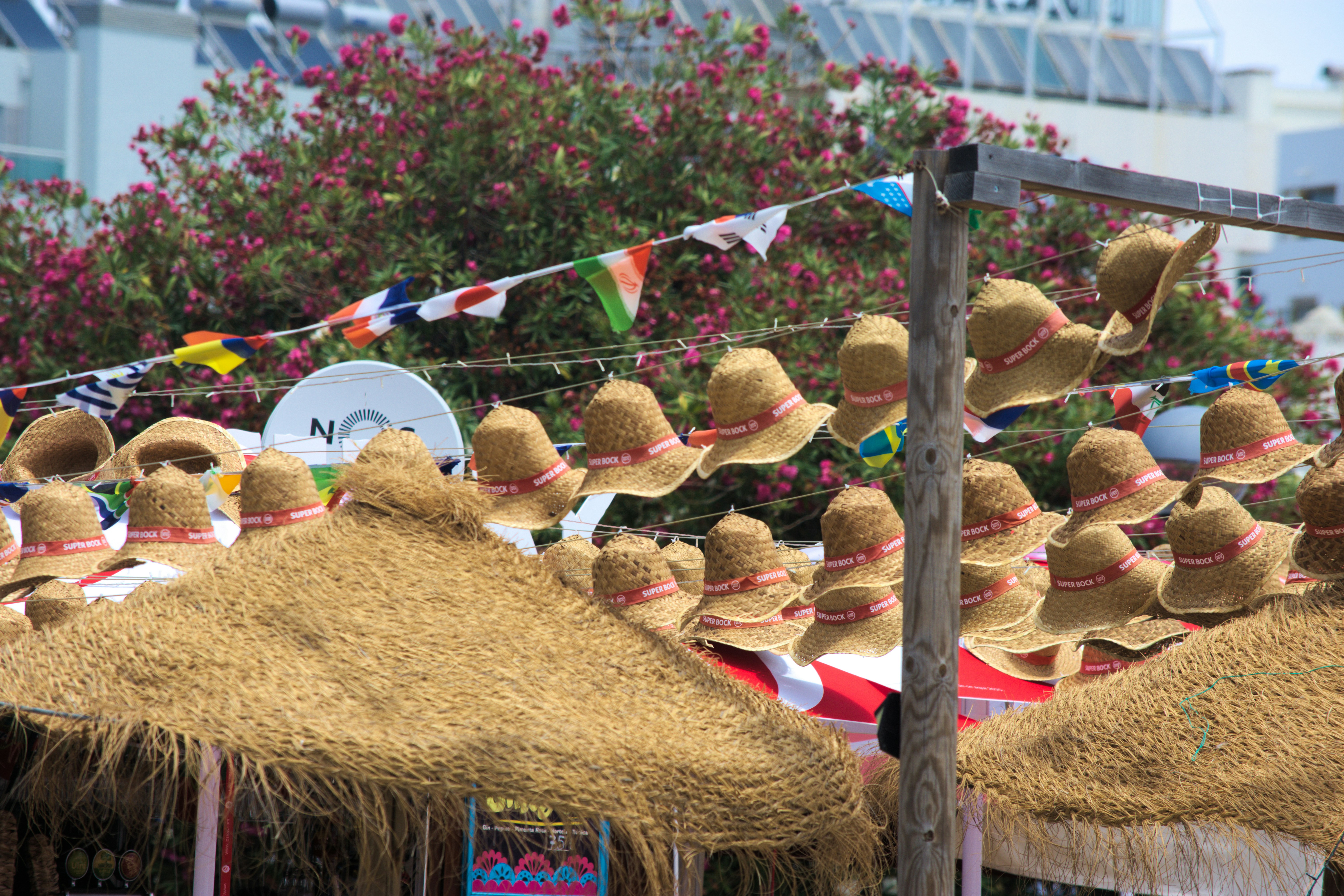Sun-Silhouetted Straw Hut Village Under Colorful Canopy