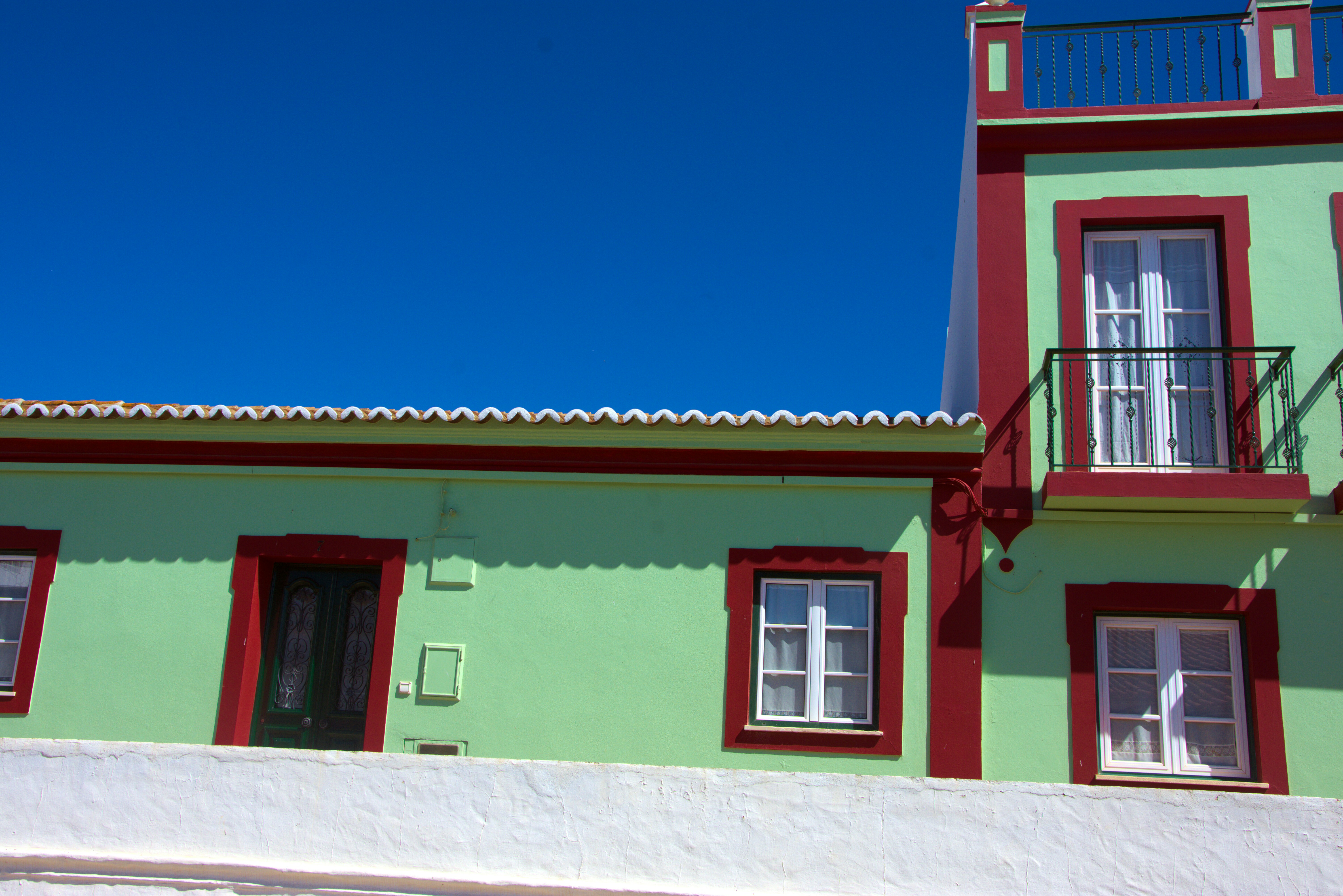 Sunlit Facade in Lime and Crimson: A Snapshot of Colorful Architecture