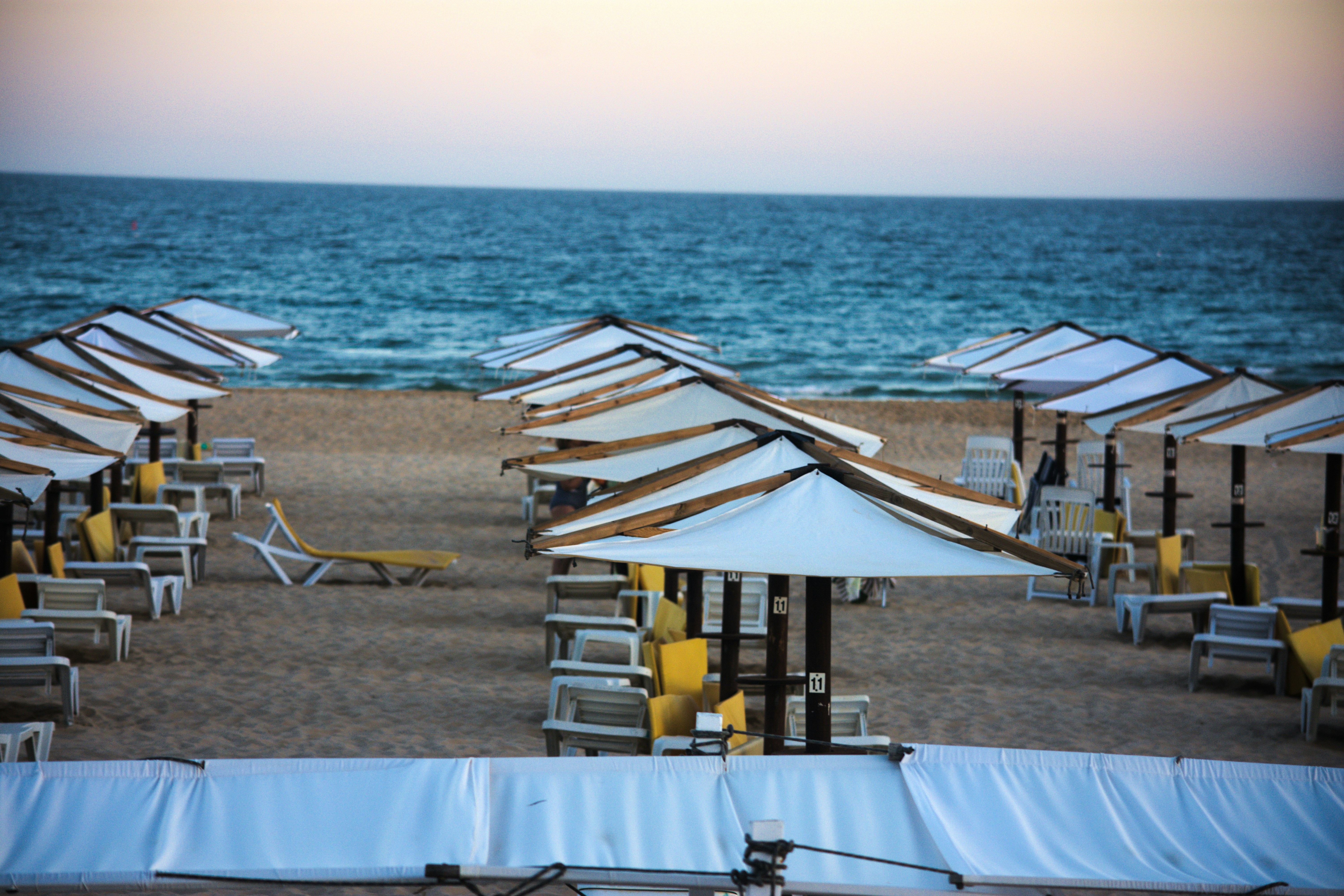 Row of beach loungers marching toward the horizon