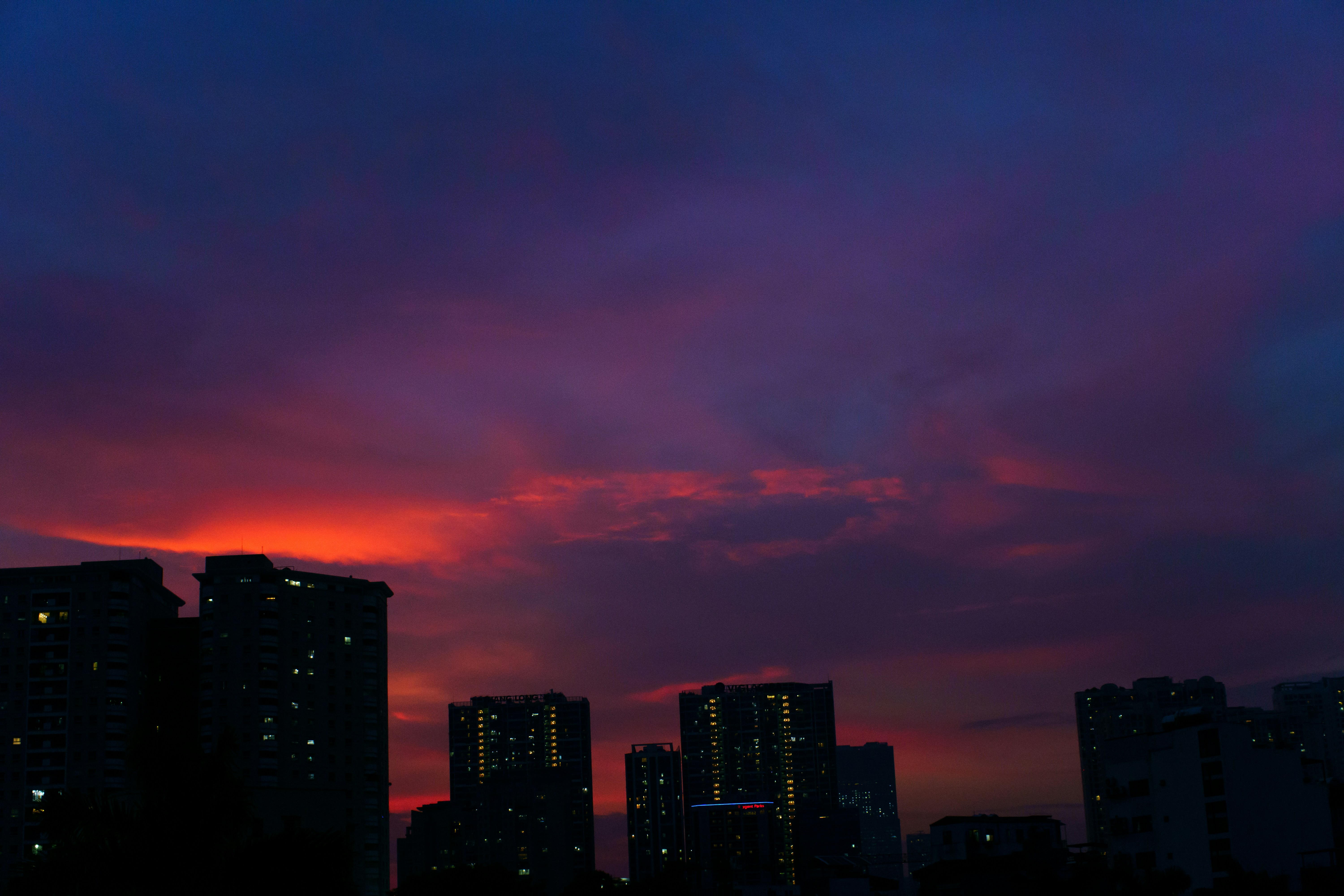 Dusk Over the City: Neon Peaks Beneath a Fiery Sky