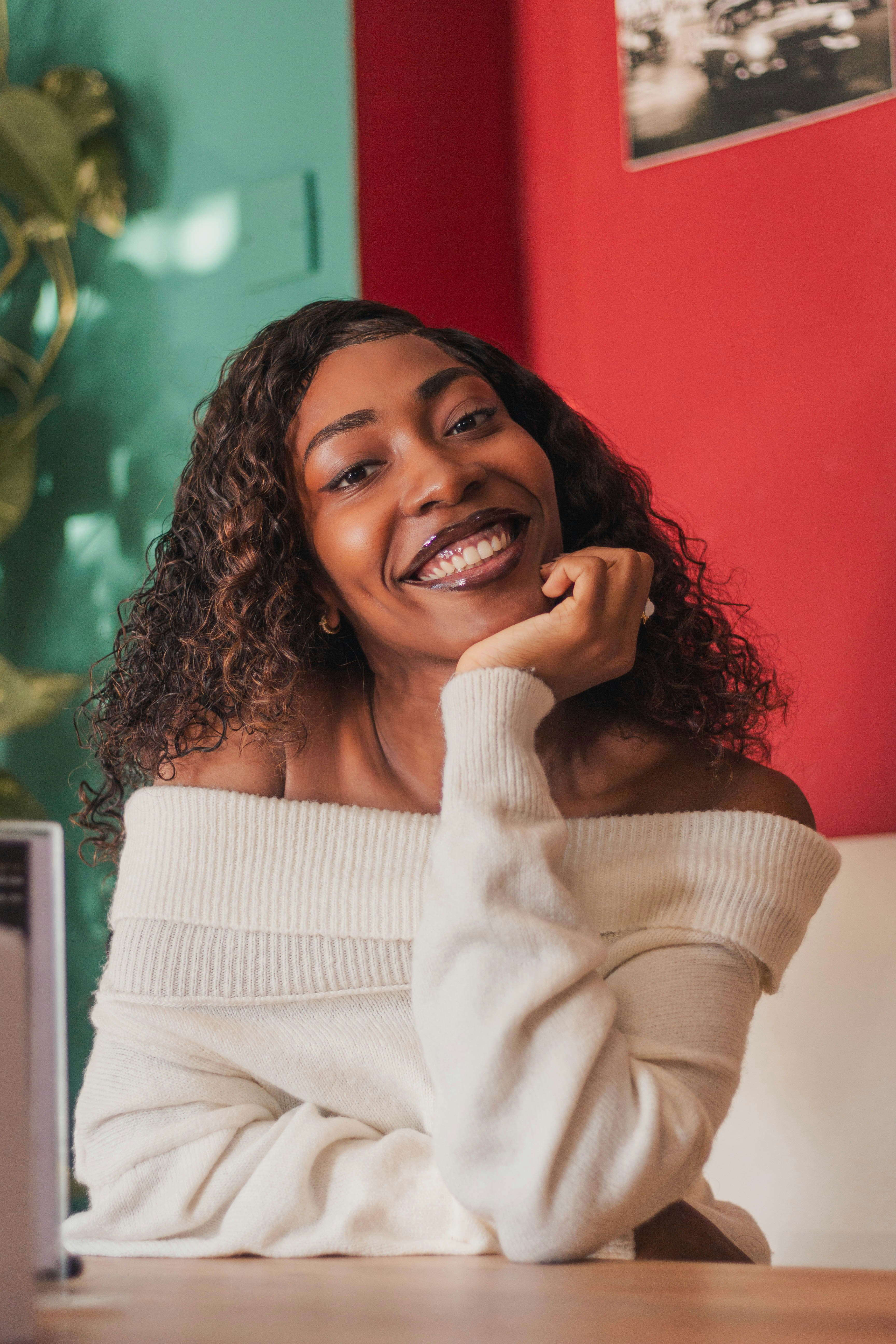 Warm studio portrait of a smiling woman with off-shoulder sweater