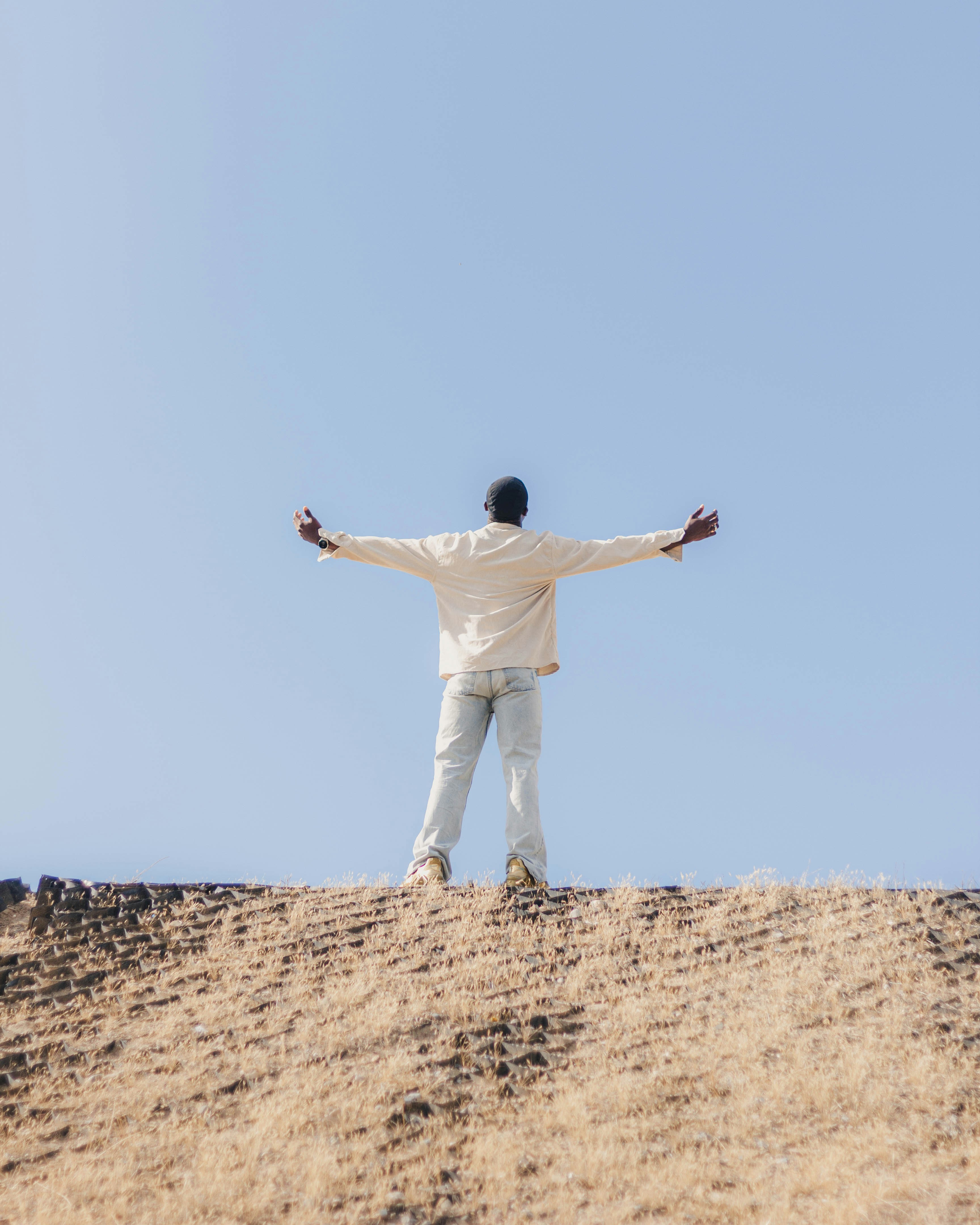 Ridge Top Sentinel: A Lone Figure with Arms Wide on the Horizon