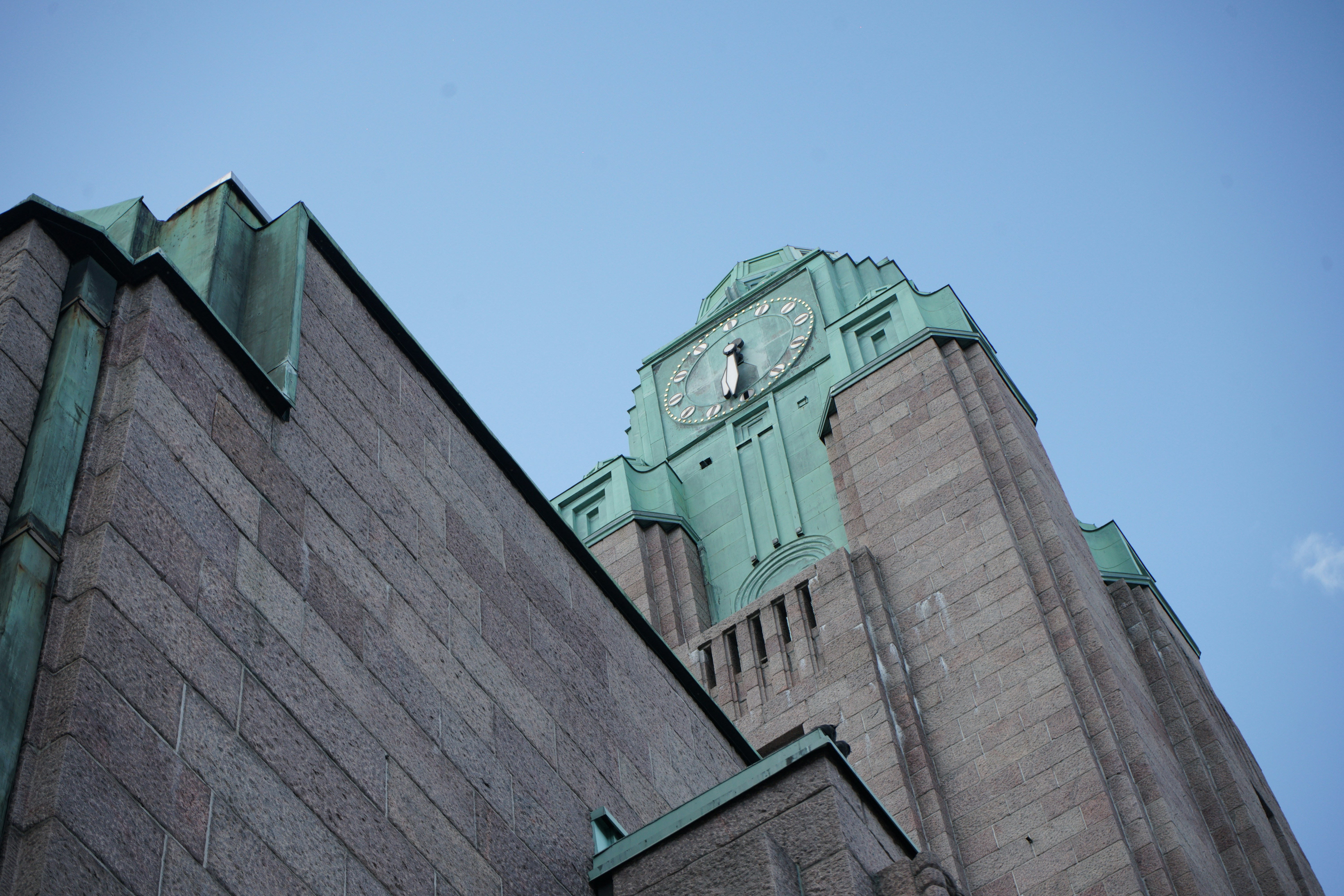 Clock Tower Under a Blue Sky — Geometric Stone and Green Copper
