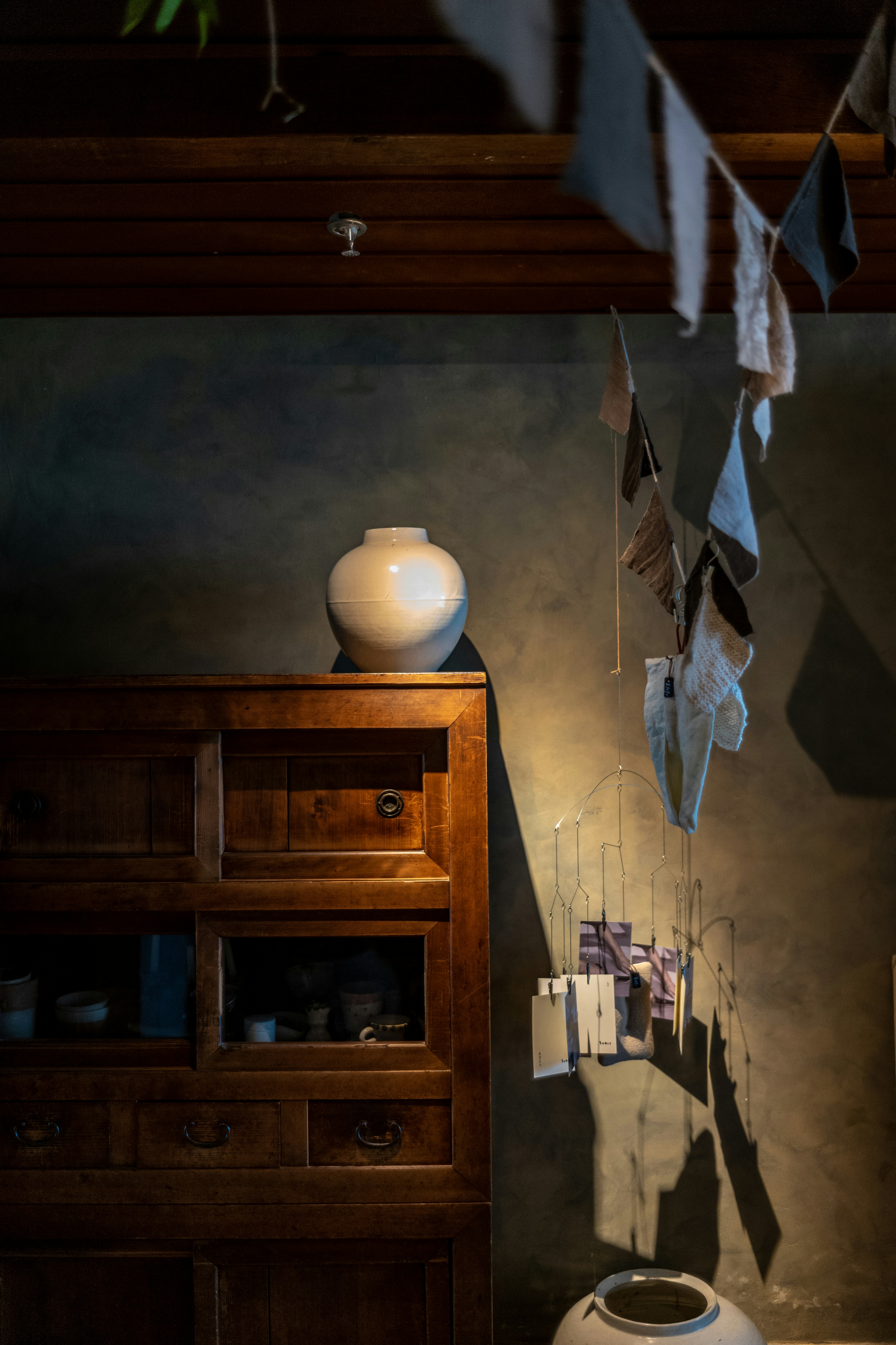 Ceramic Vessel on Wooden Cabinet Under Soft Studio Light