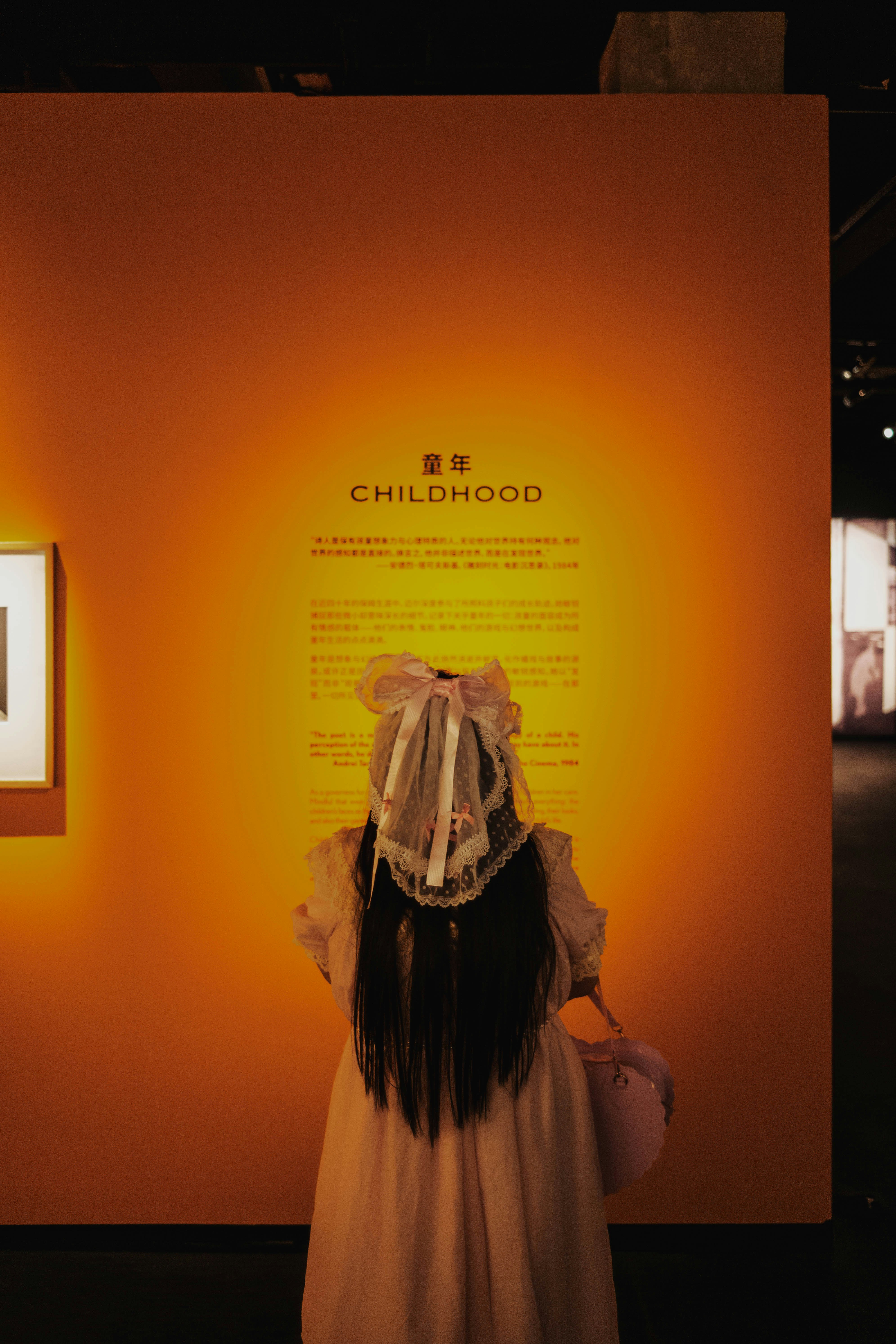 Backlit Inheritance: A Silhouette Beneath a Warm Exhibit Glow