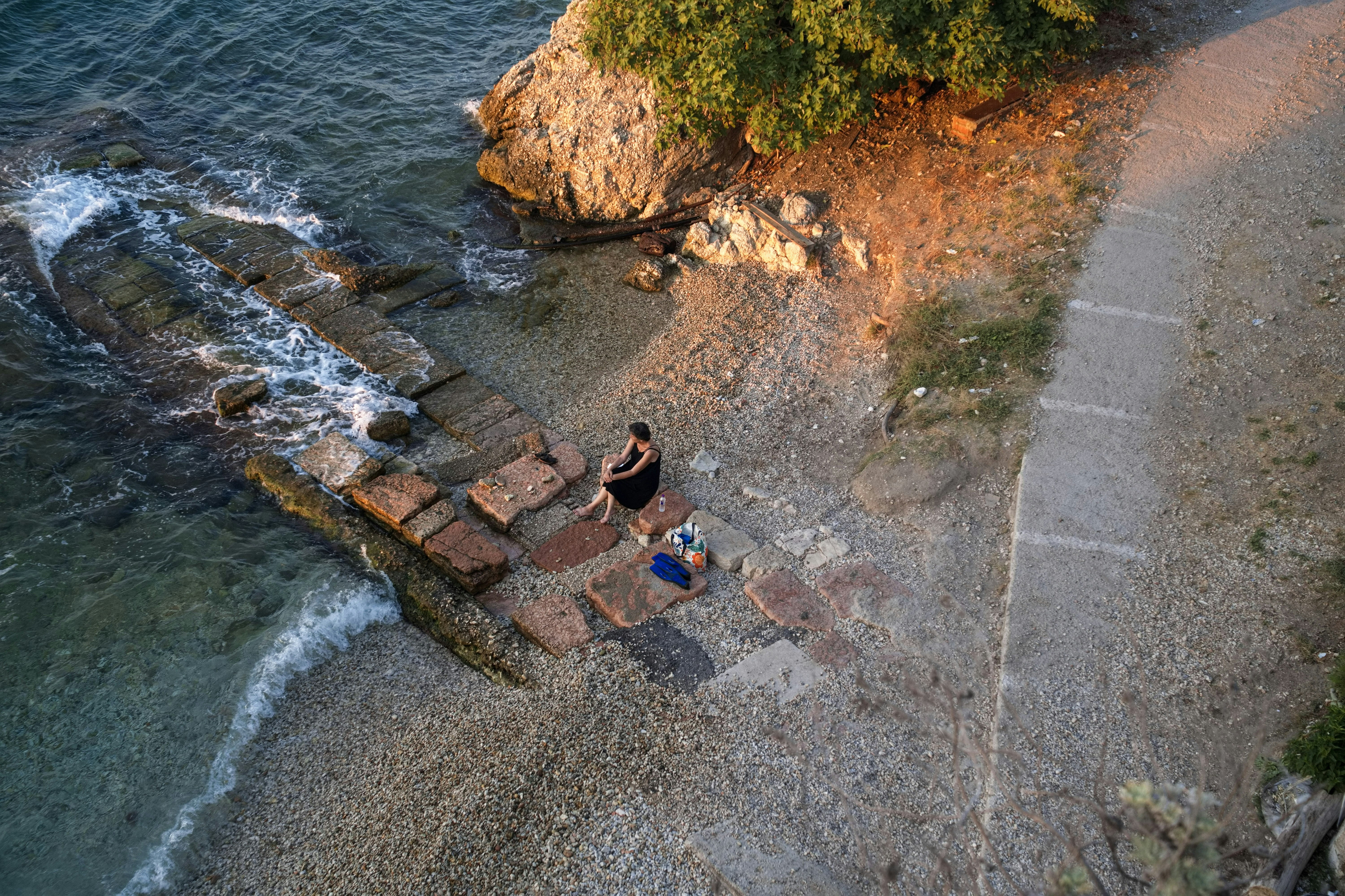 Coastal Shoreline Moment: Two Figures on Pebble Beach Near the Crag
