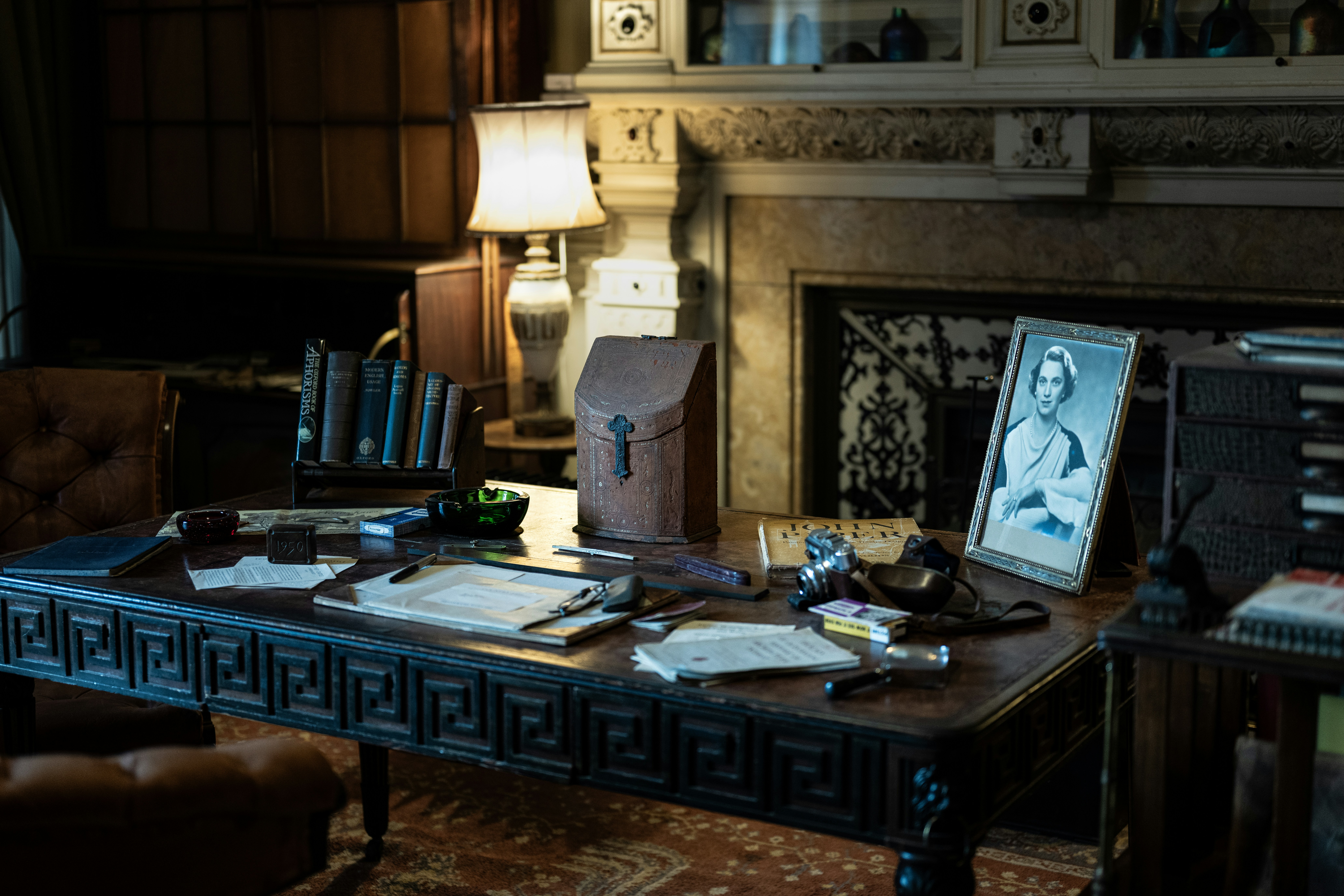A Quiet Study: Antique Desk, Portrait, and Warm Lamp Glow