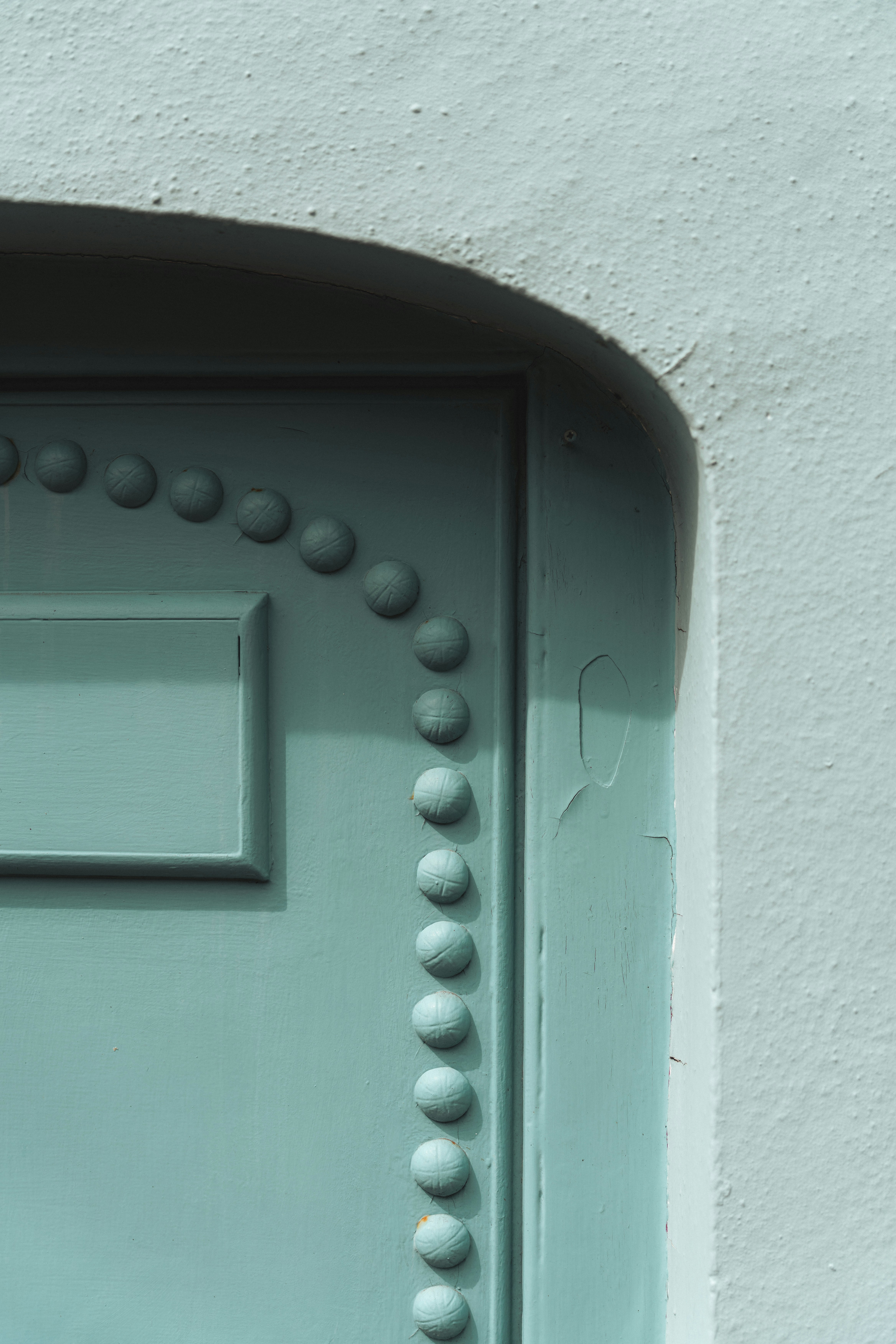 Minted Doorway: A Close-Up on a Dented Turquoise Panel