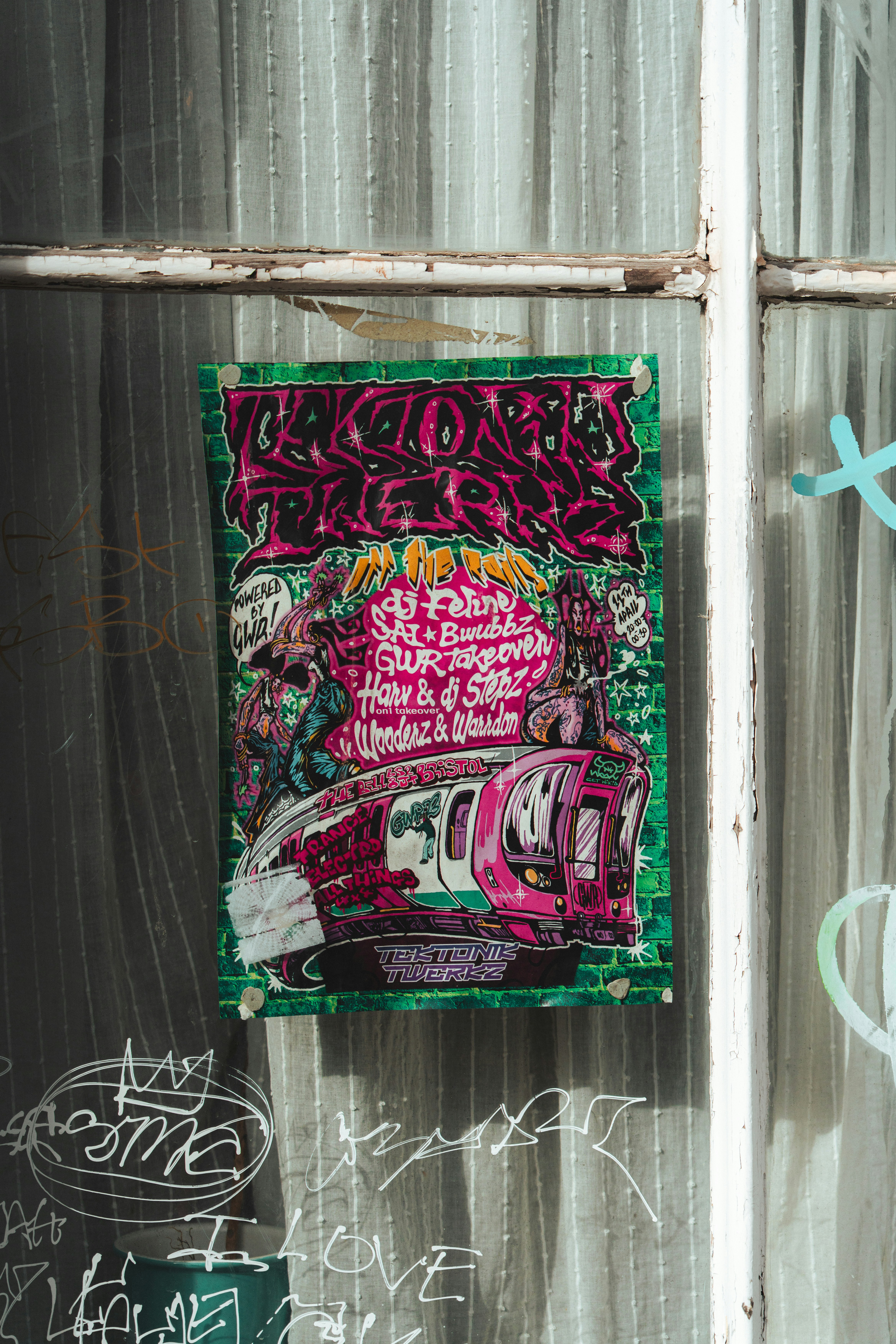 Neon Poster on Graffitied Window: Vivid Street Art Fixture