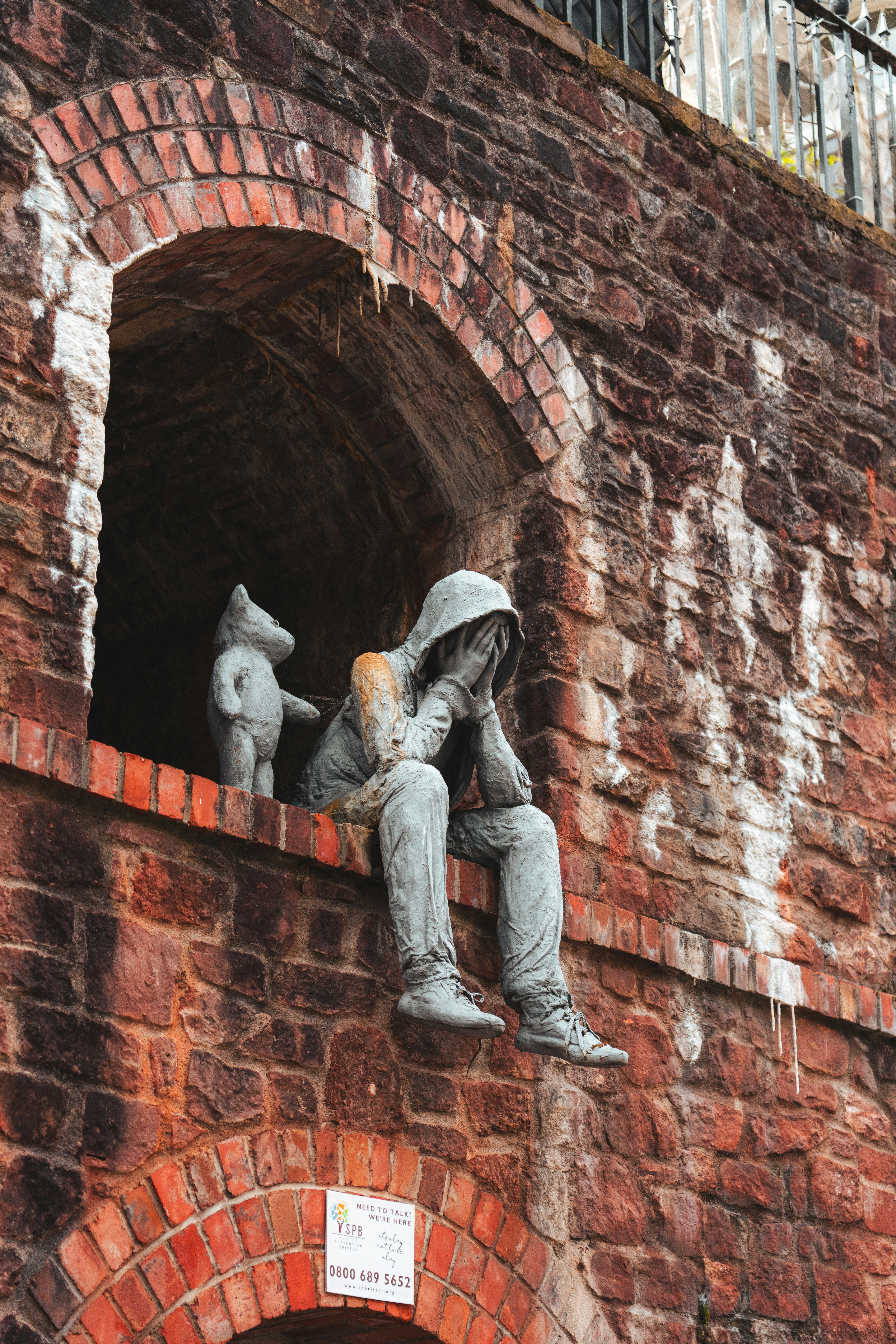 Hollowed Out Solace: A Grim Figure at the Brick Arch