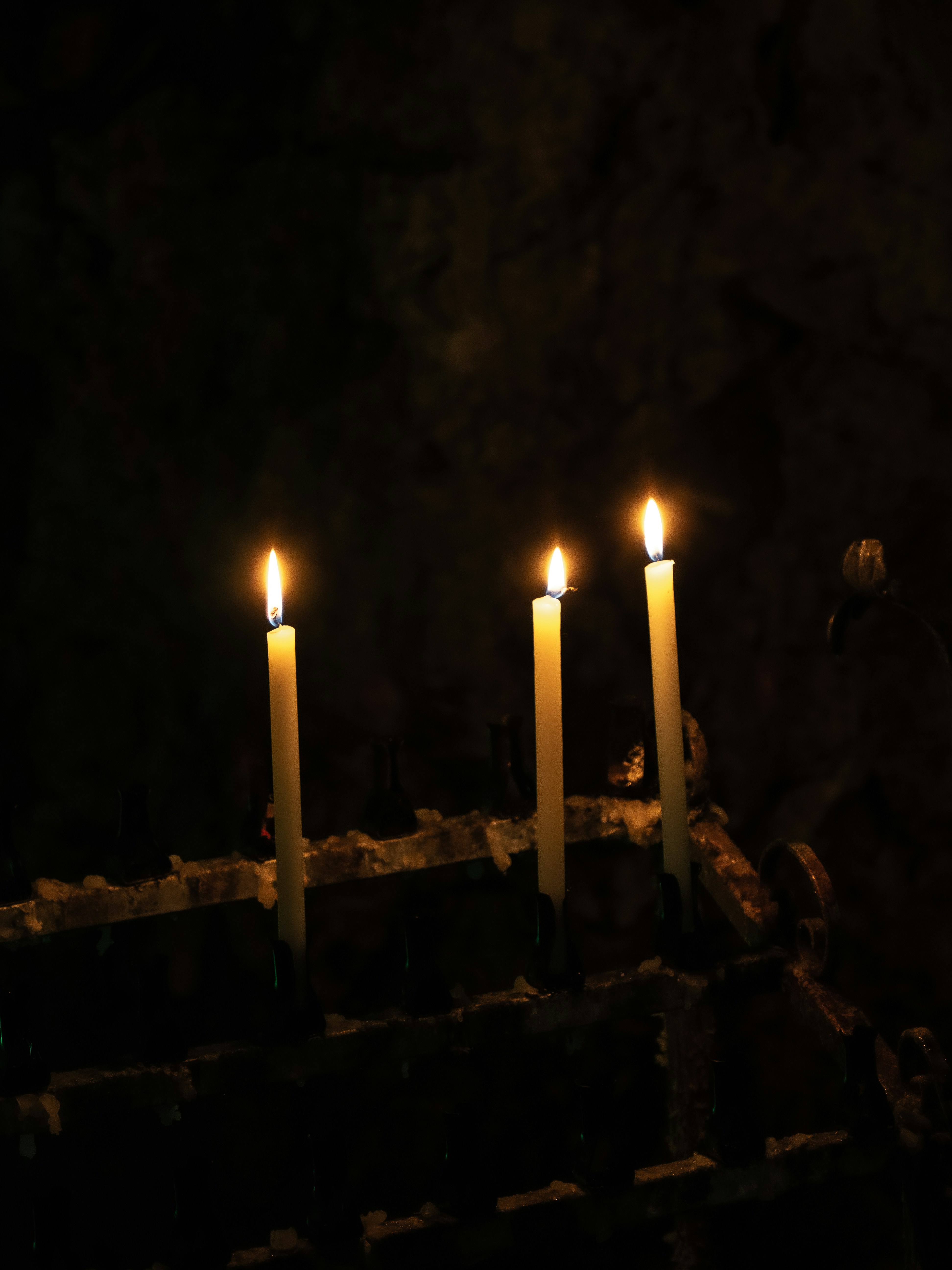 Three Candlelit Columns in a Dark Sanctuary