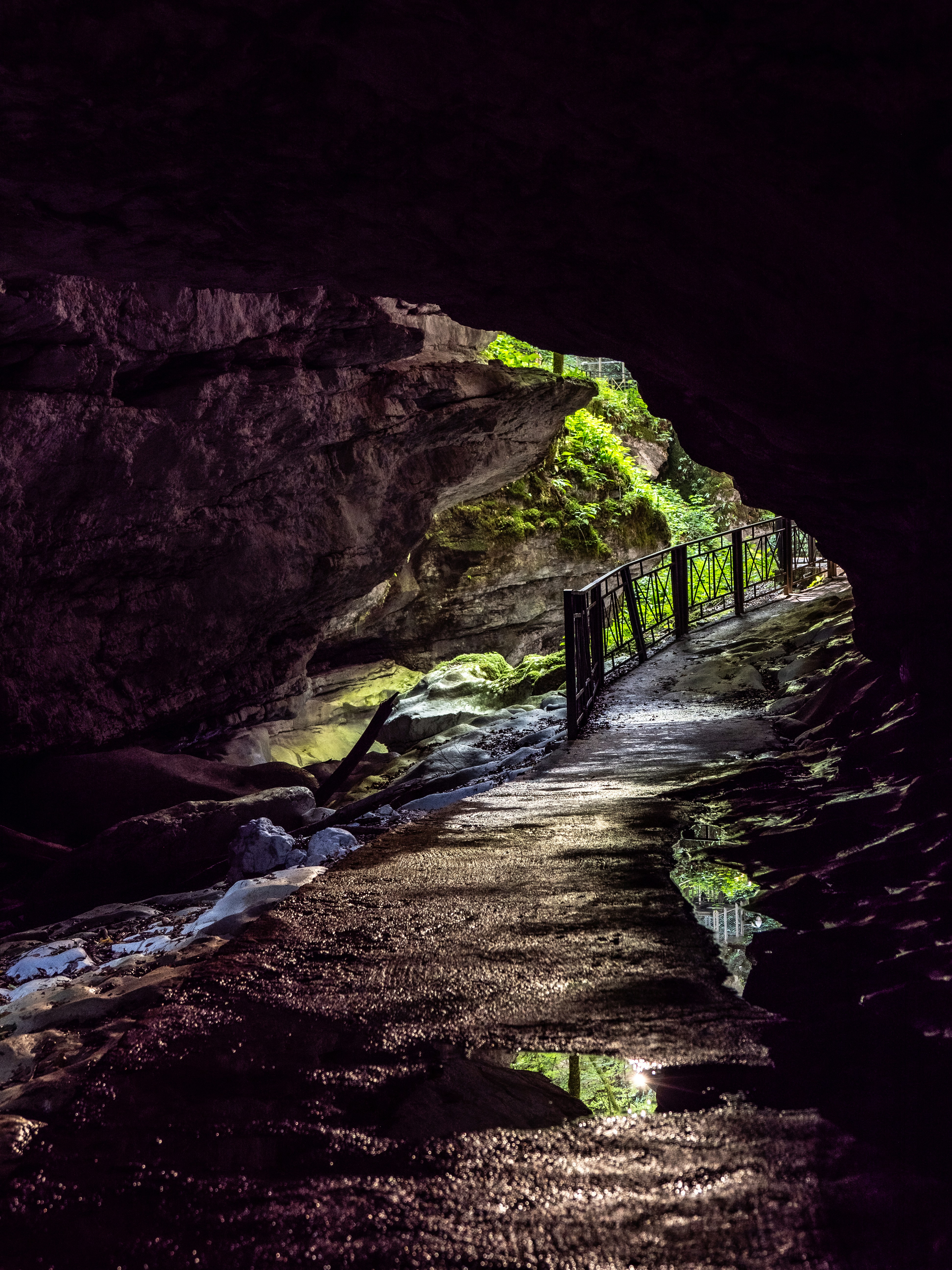 Path Through the Cave: Sunlit Rail Against Shadowed Rock