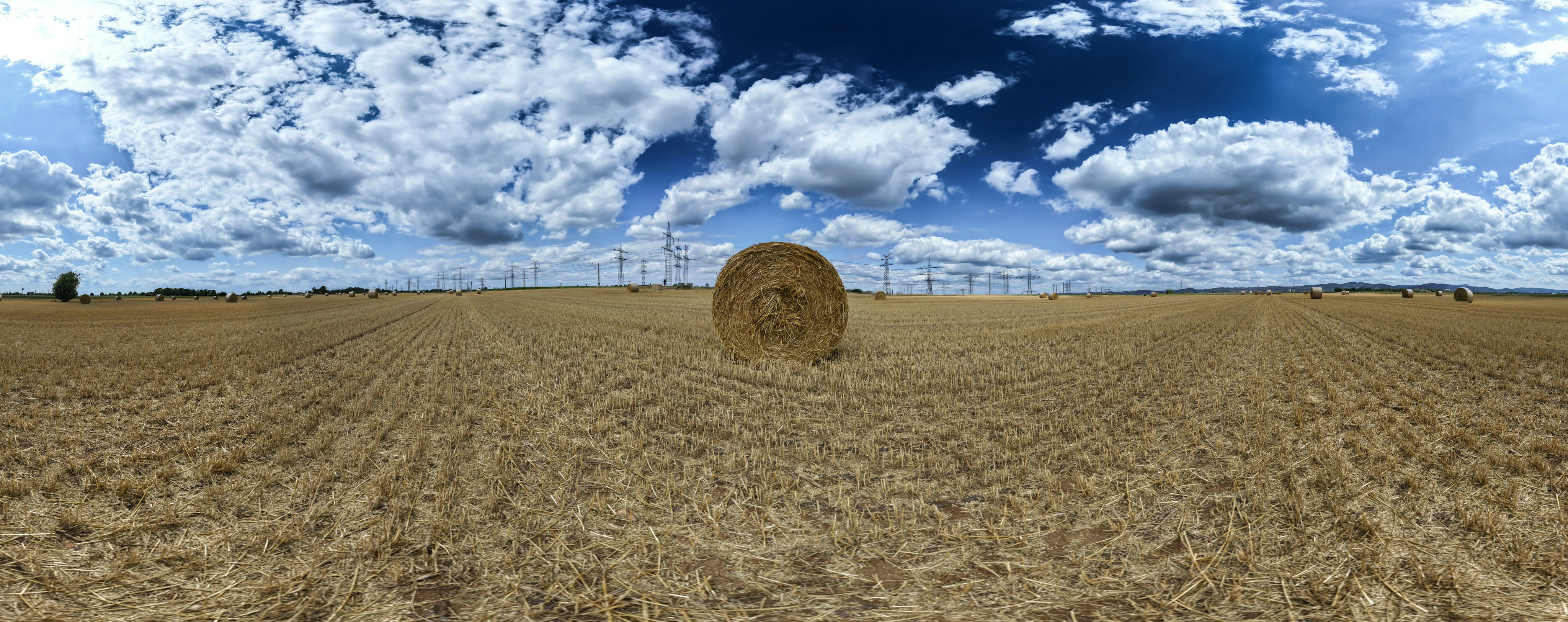 Harvest Horizon: A Lone Hay Bale in a Wide Open Field