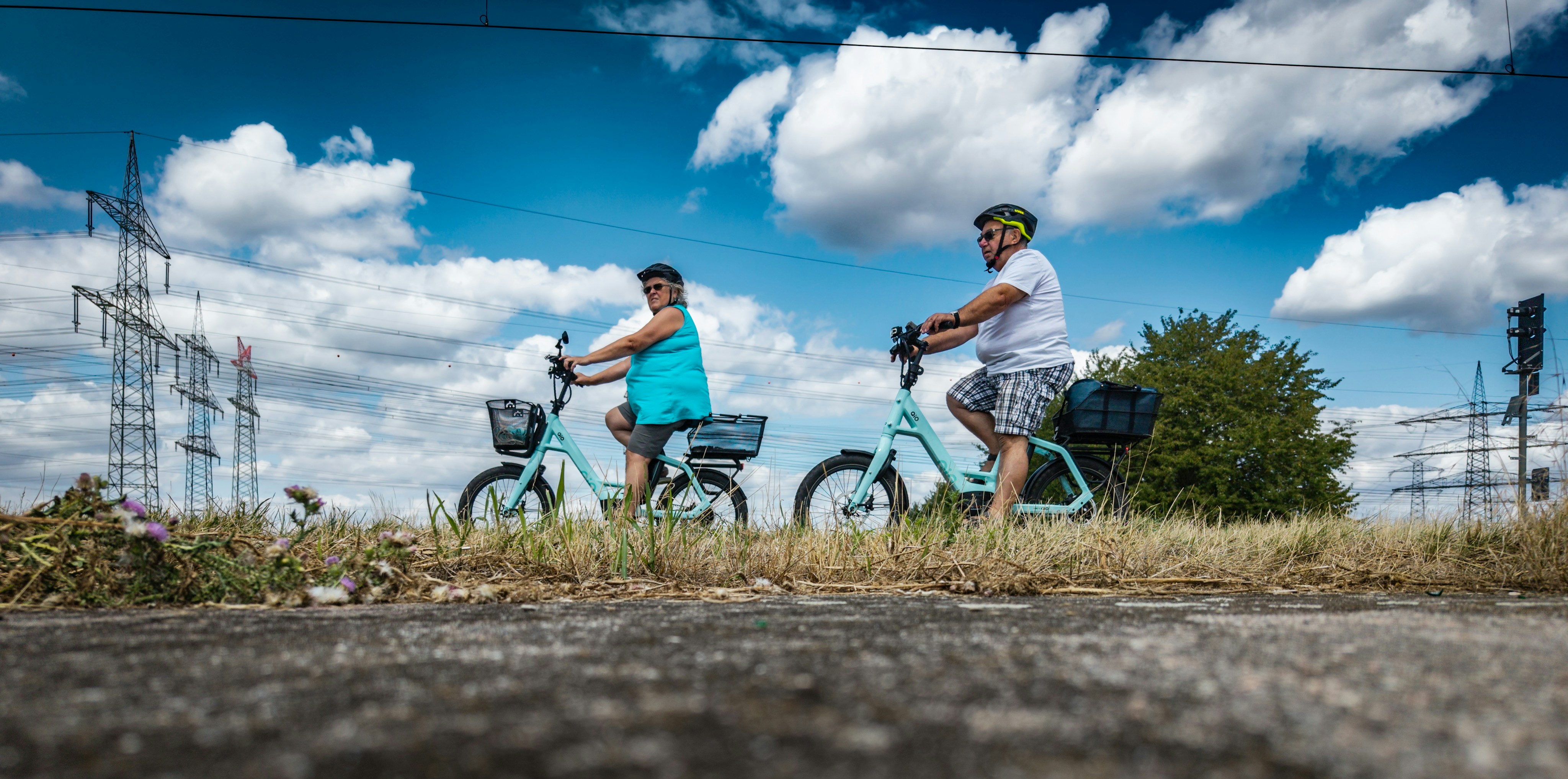 Bicycles on a sunlit rural road: a breezy duo ride past power lines