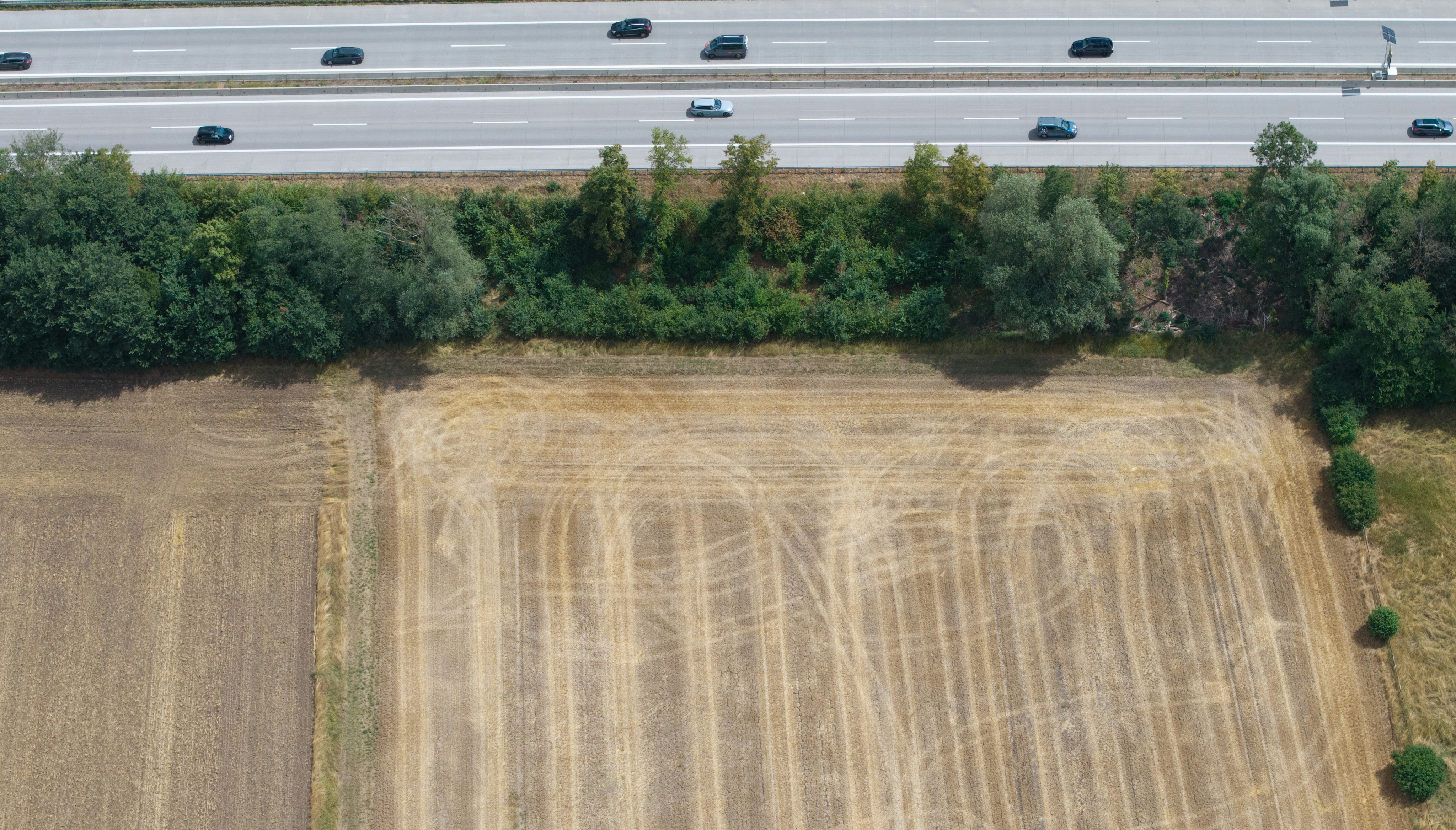 Aerial View of a Highway Bordering a Plowed Field