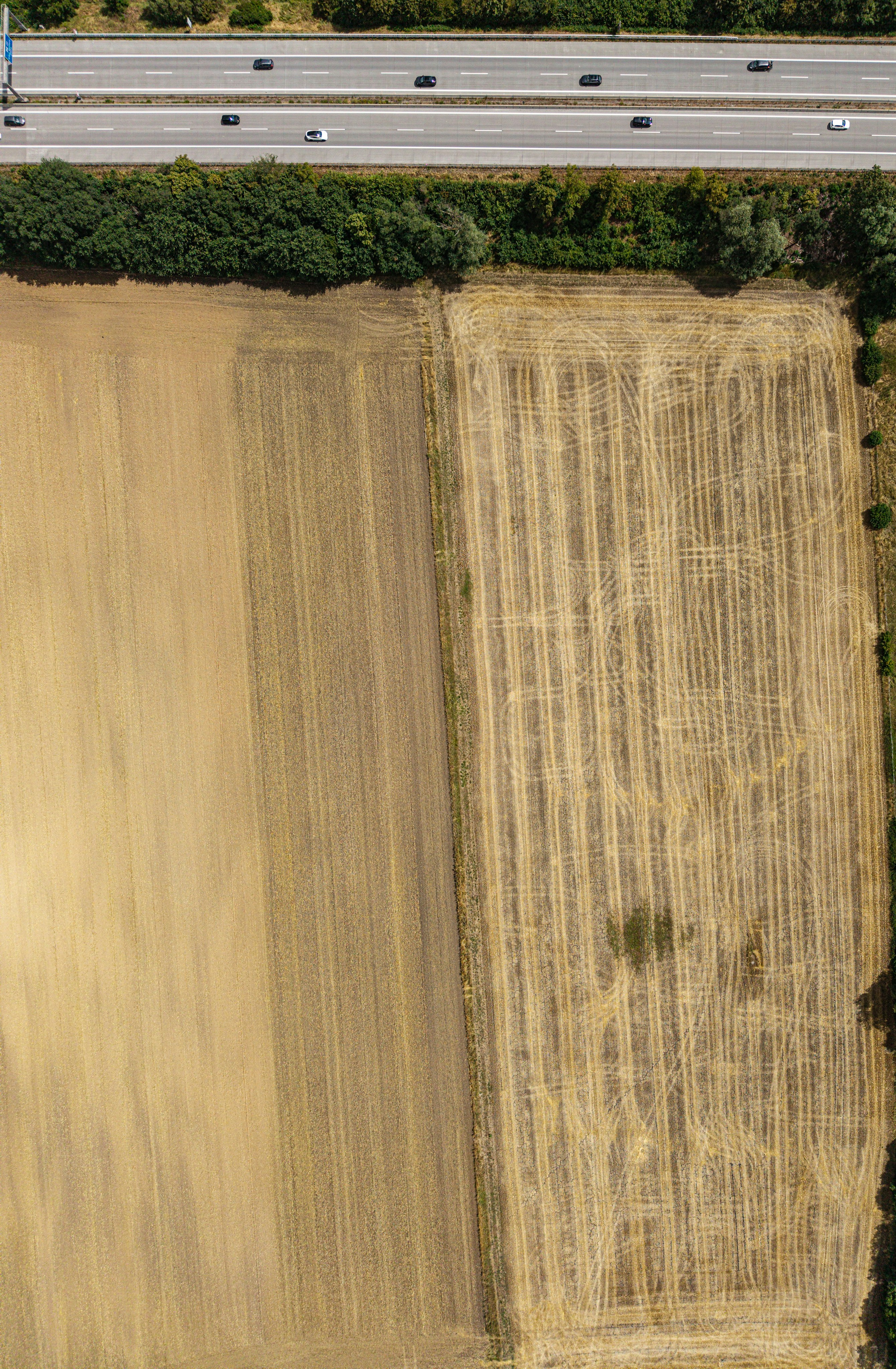 Highway Edge: Aerial View of Harvested Fields and Tree Line