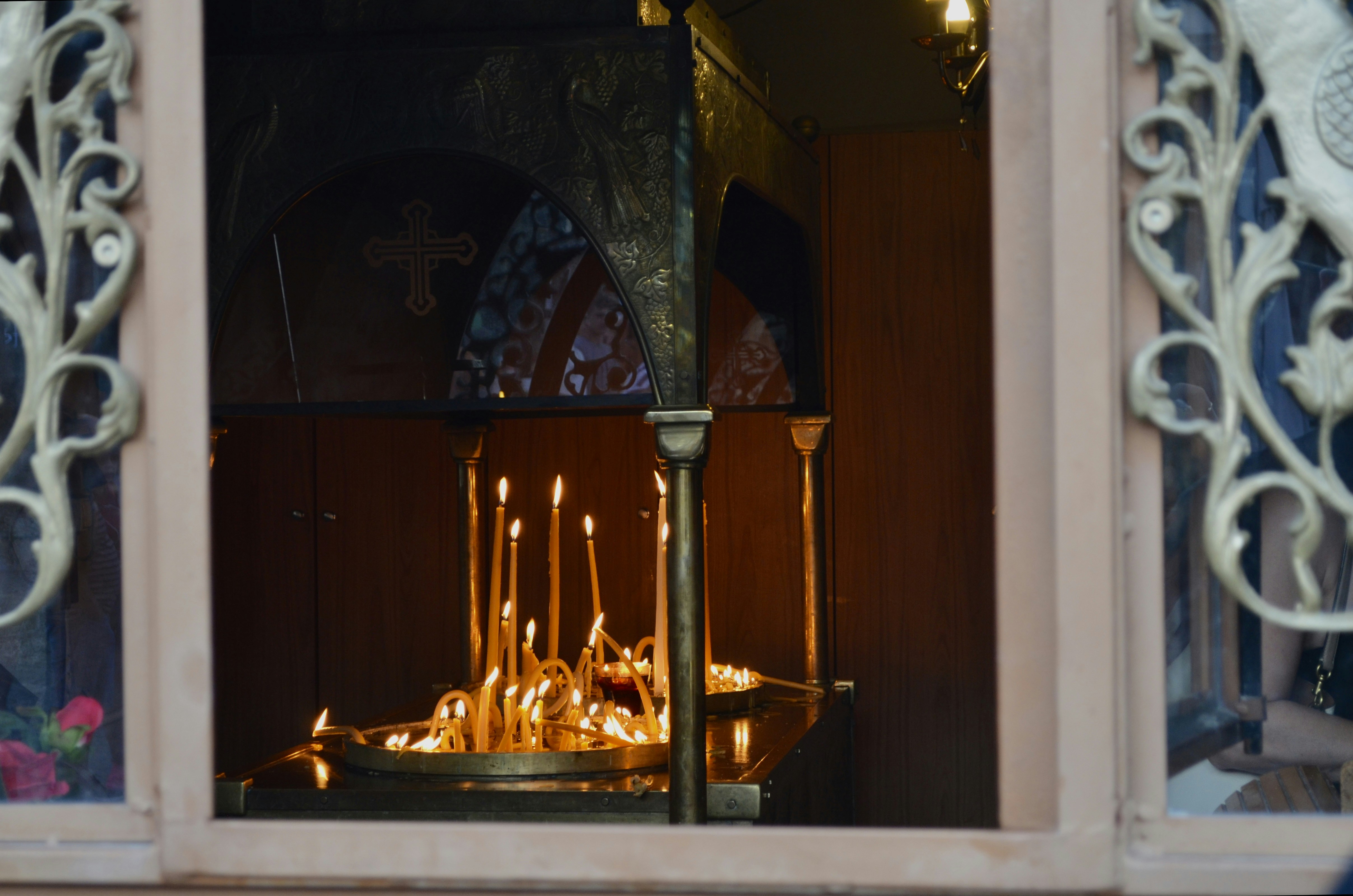 Candlelit Shrine Window: Quiet Reverence Through Ornate Ironwork