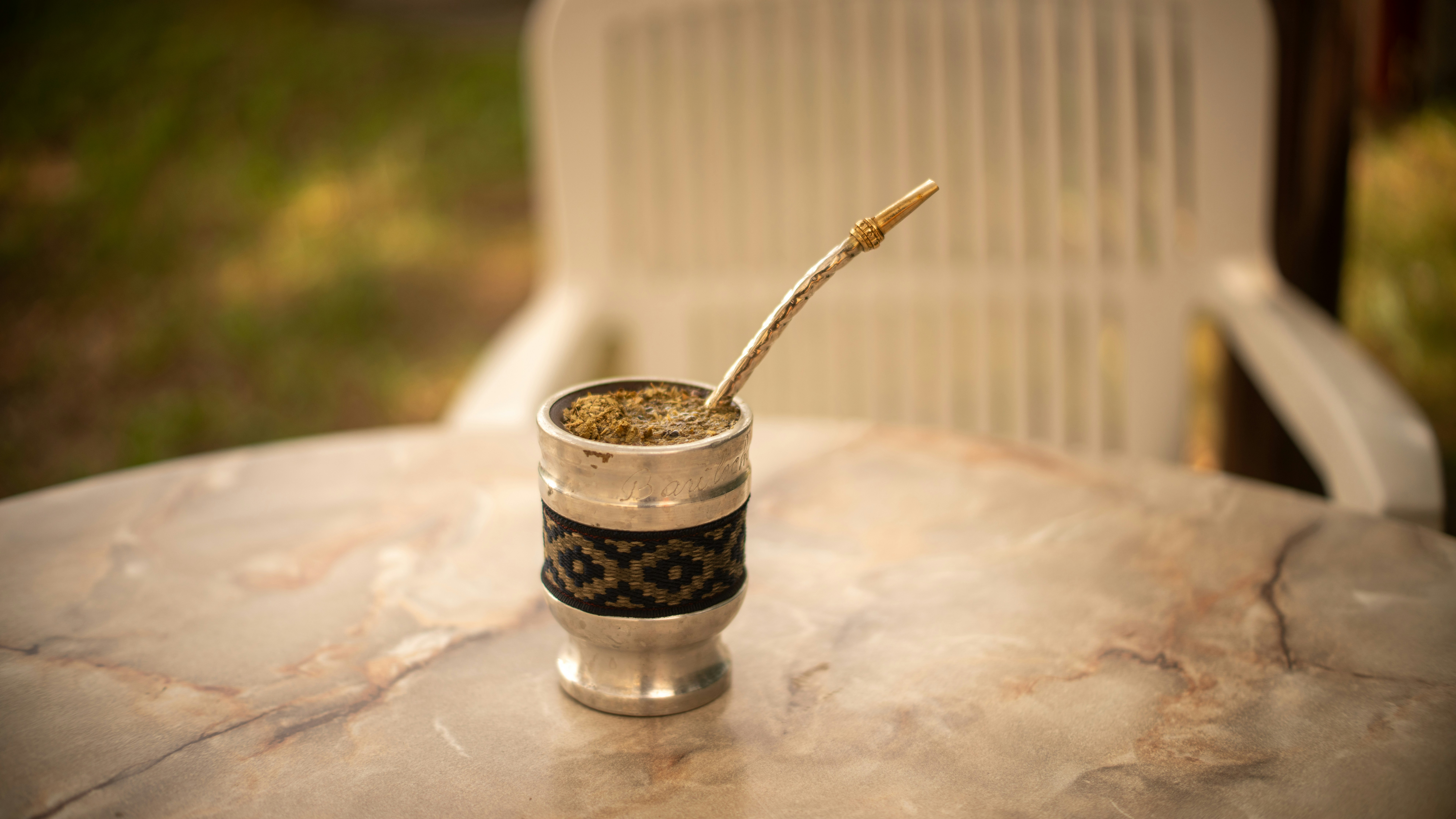 Dusty cup with straw: a quiet table in sunlit garden