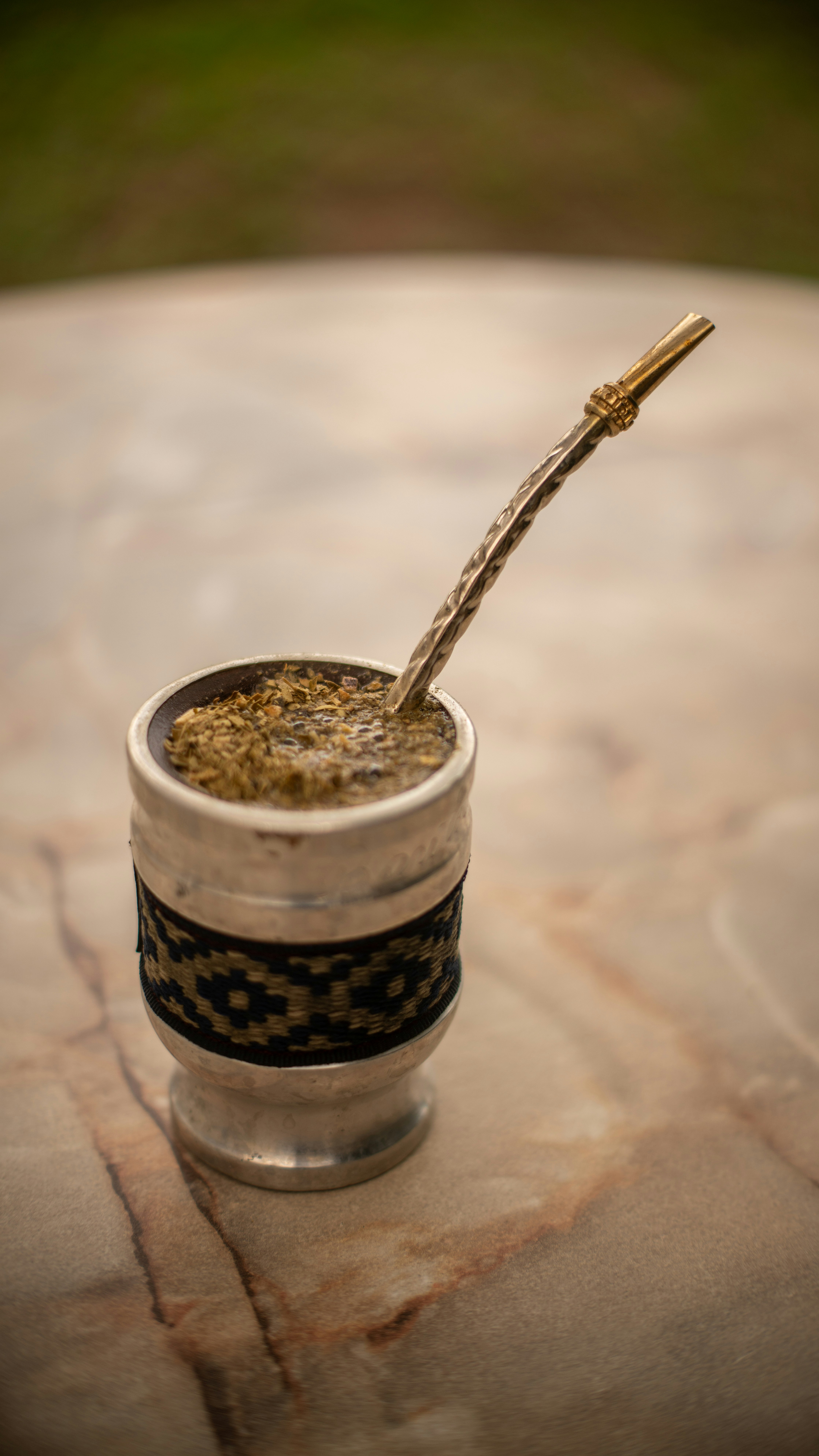 Aged cezve on a sunlit stone table with a braided pour spout