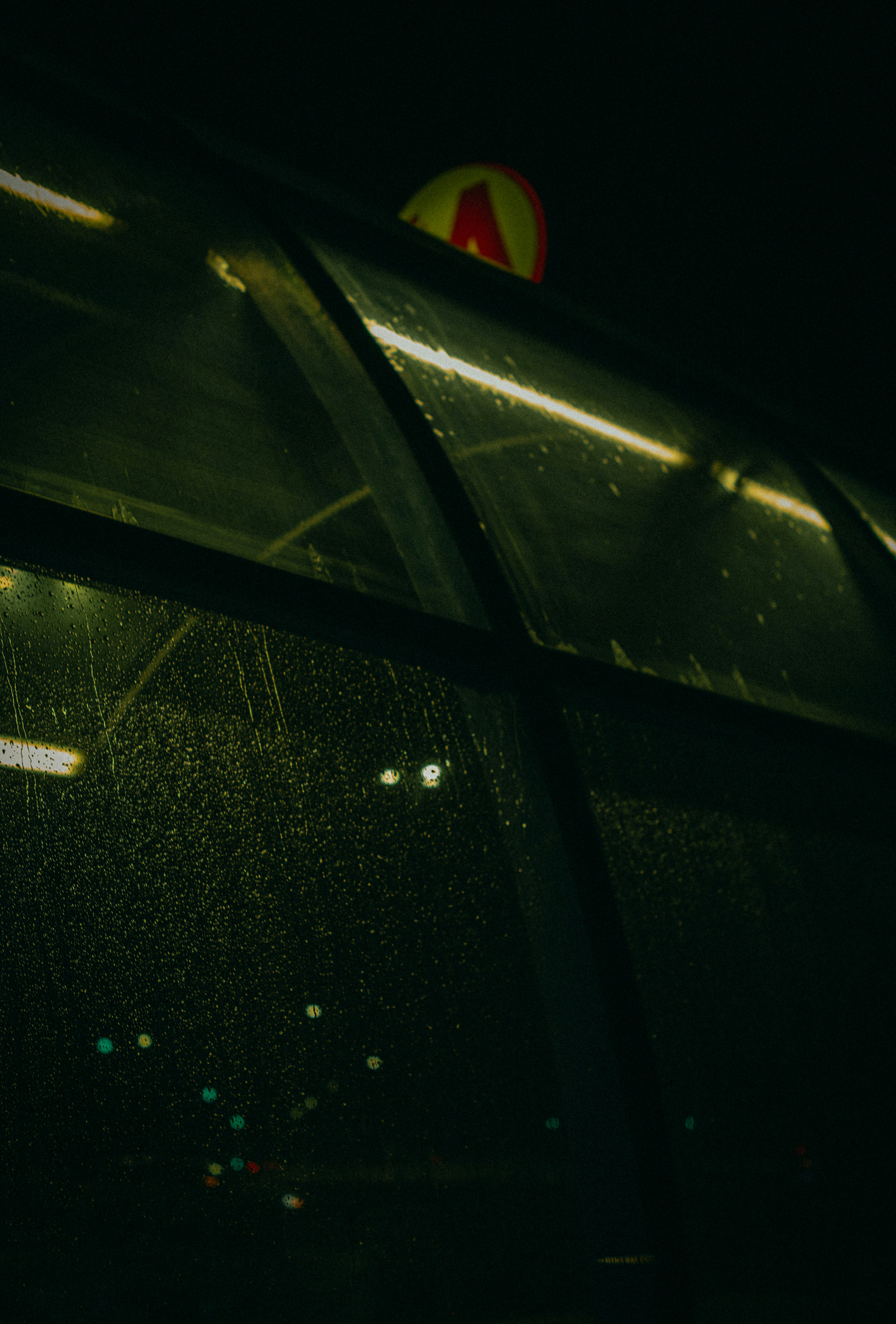 Night Ride: Neon Reflections on a Raining Window