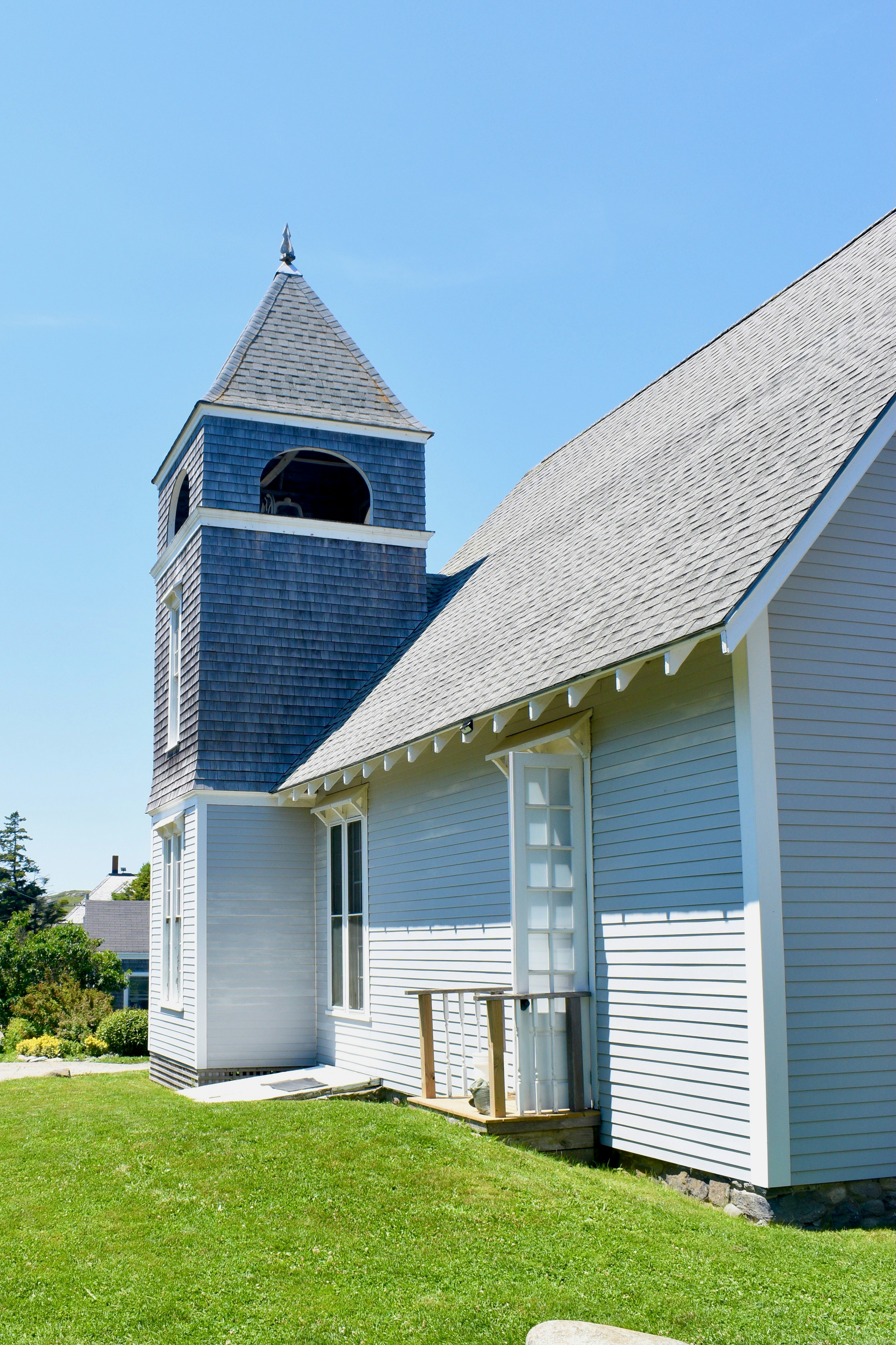 Blue Grained Bell Tower Beside a Sunlit Chapel