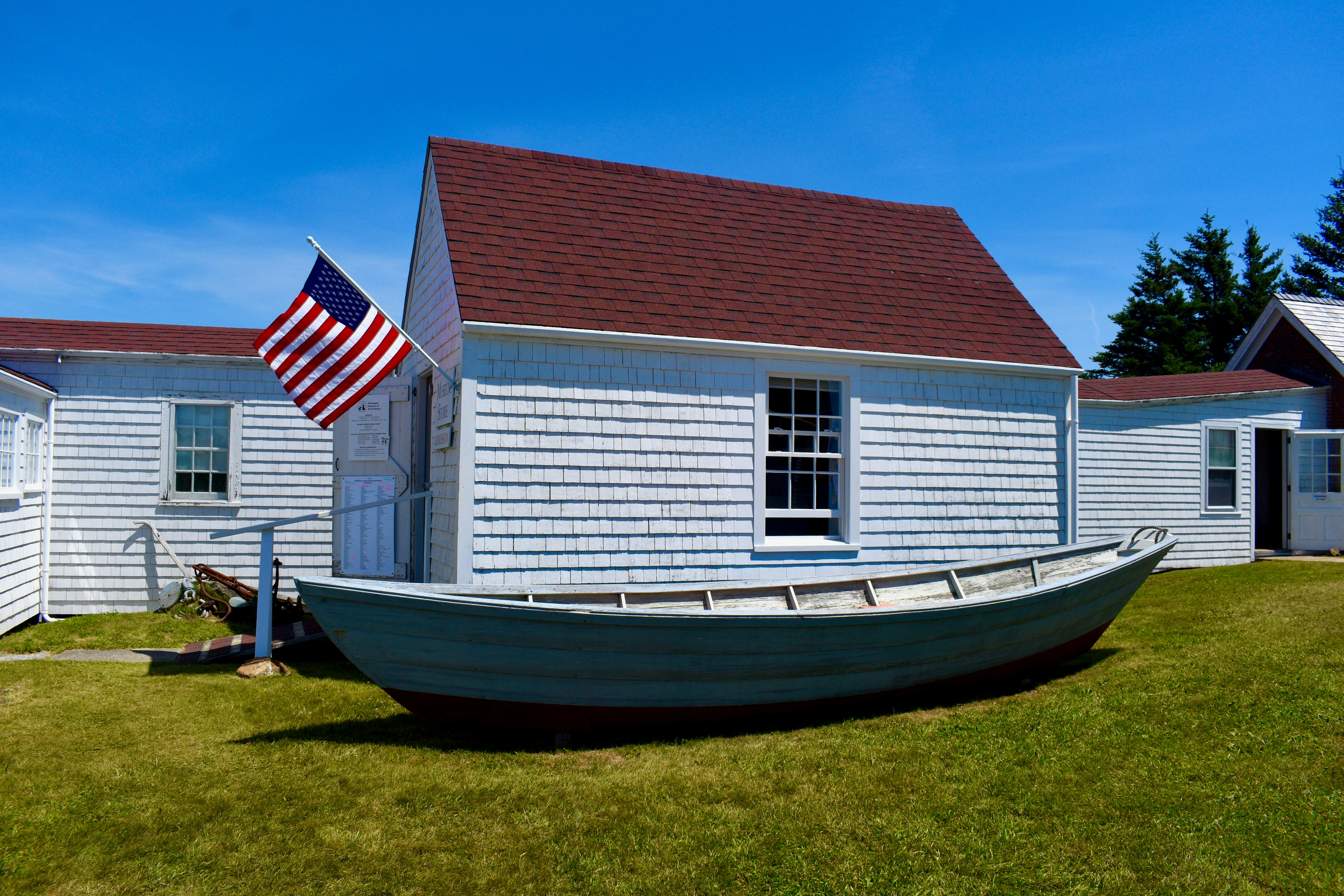 Flag, Boat, and White Cottage: A Quiet Maritime Still Life